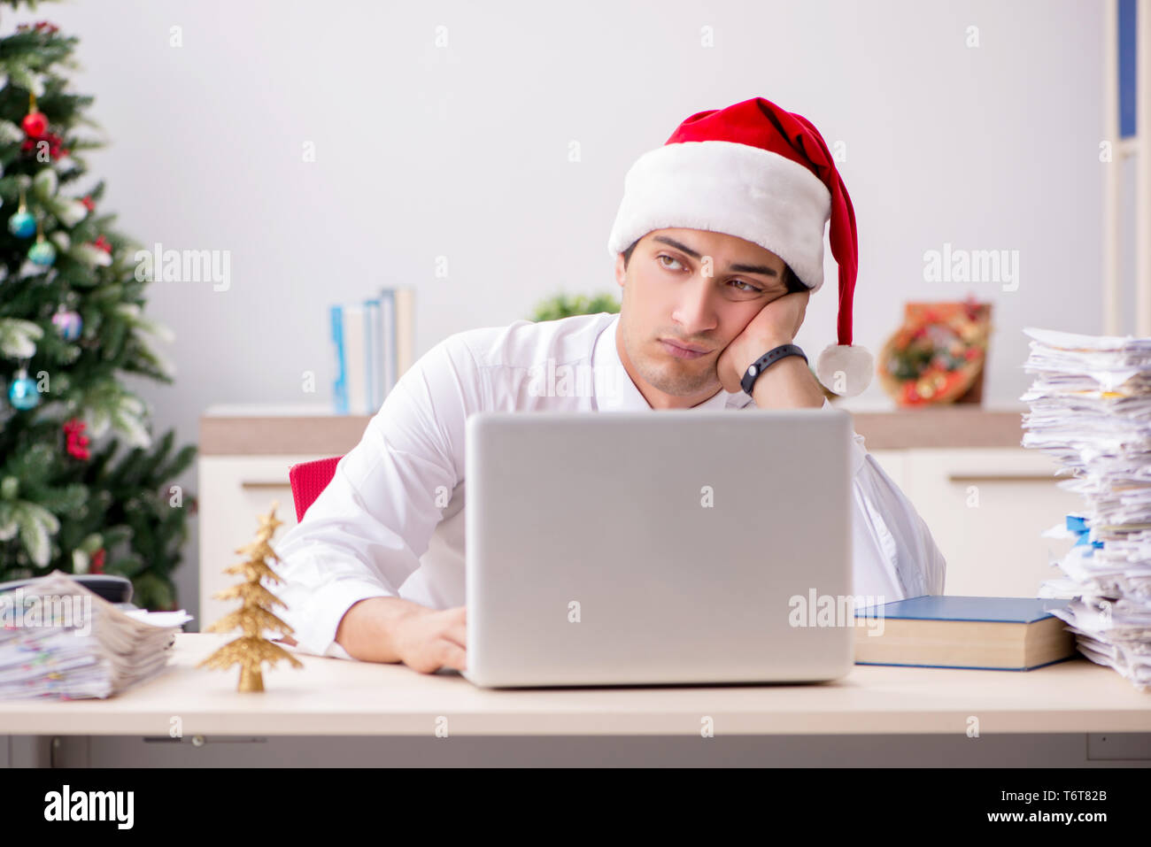 Young worker working in office on christmas shift Stock Photo - Alamy