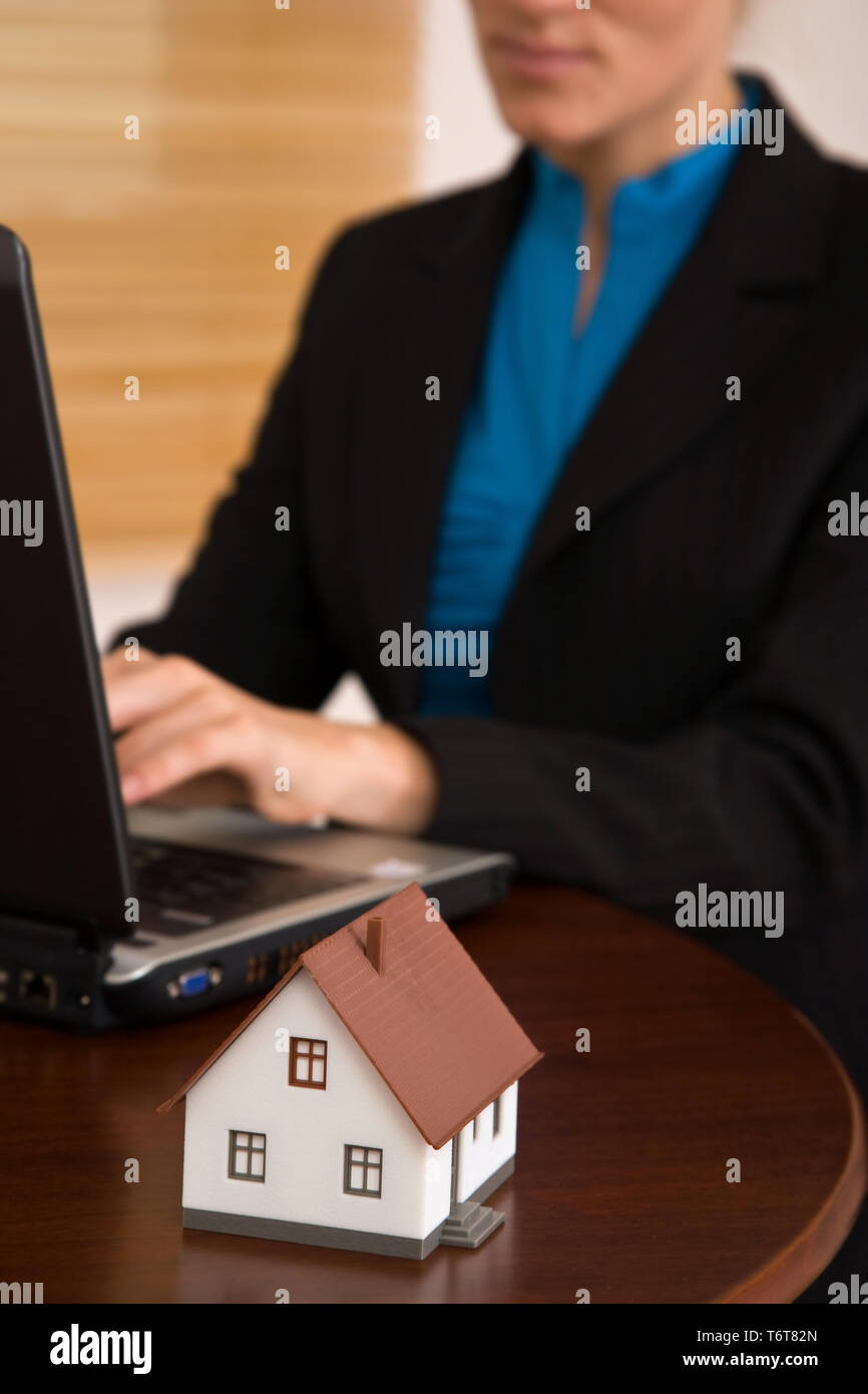 real estate concept with a mini house and a computer at the office ...