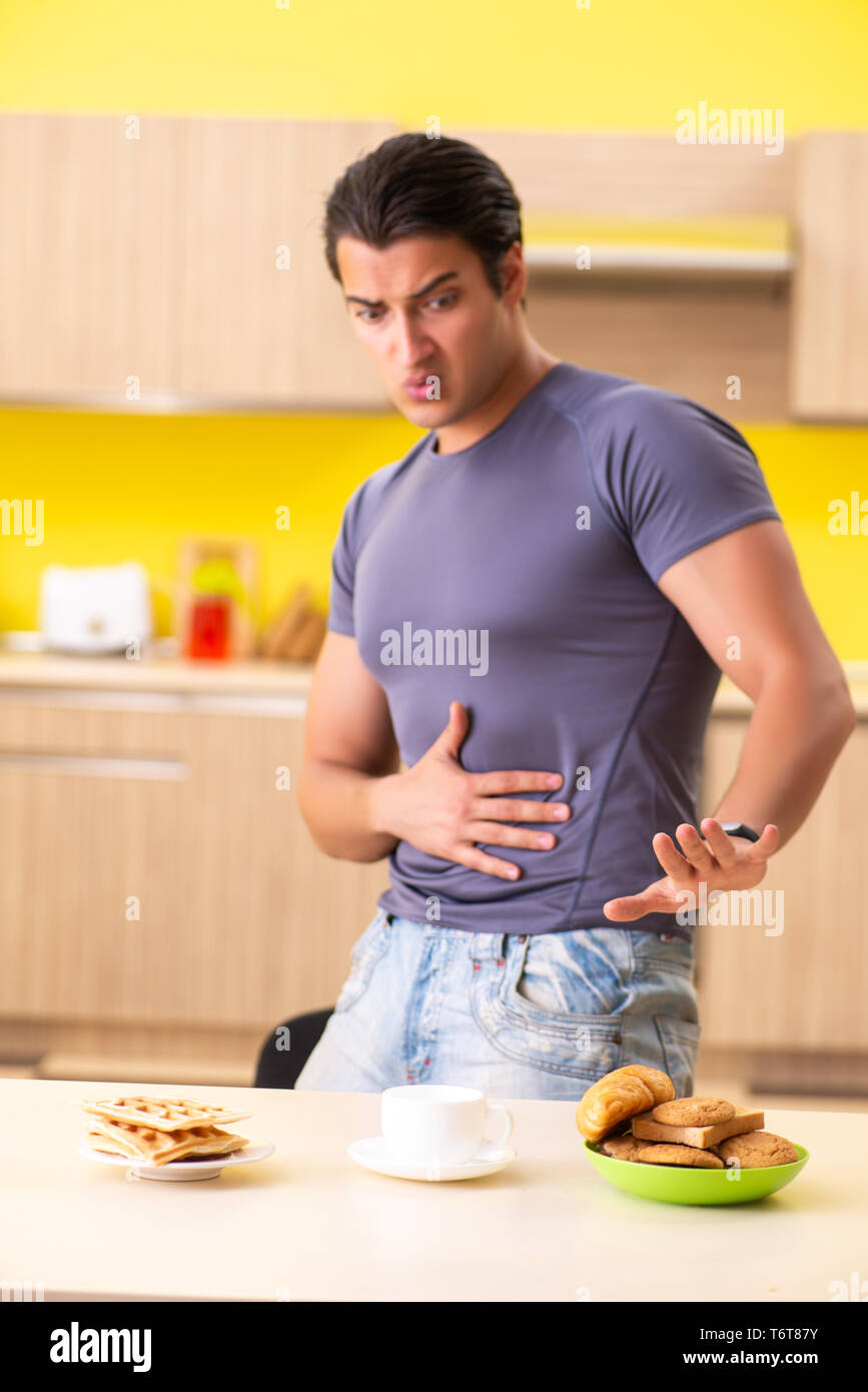 Young man in unhealthy food concept Stock Photo - Alamy