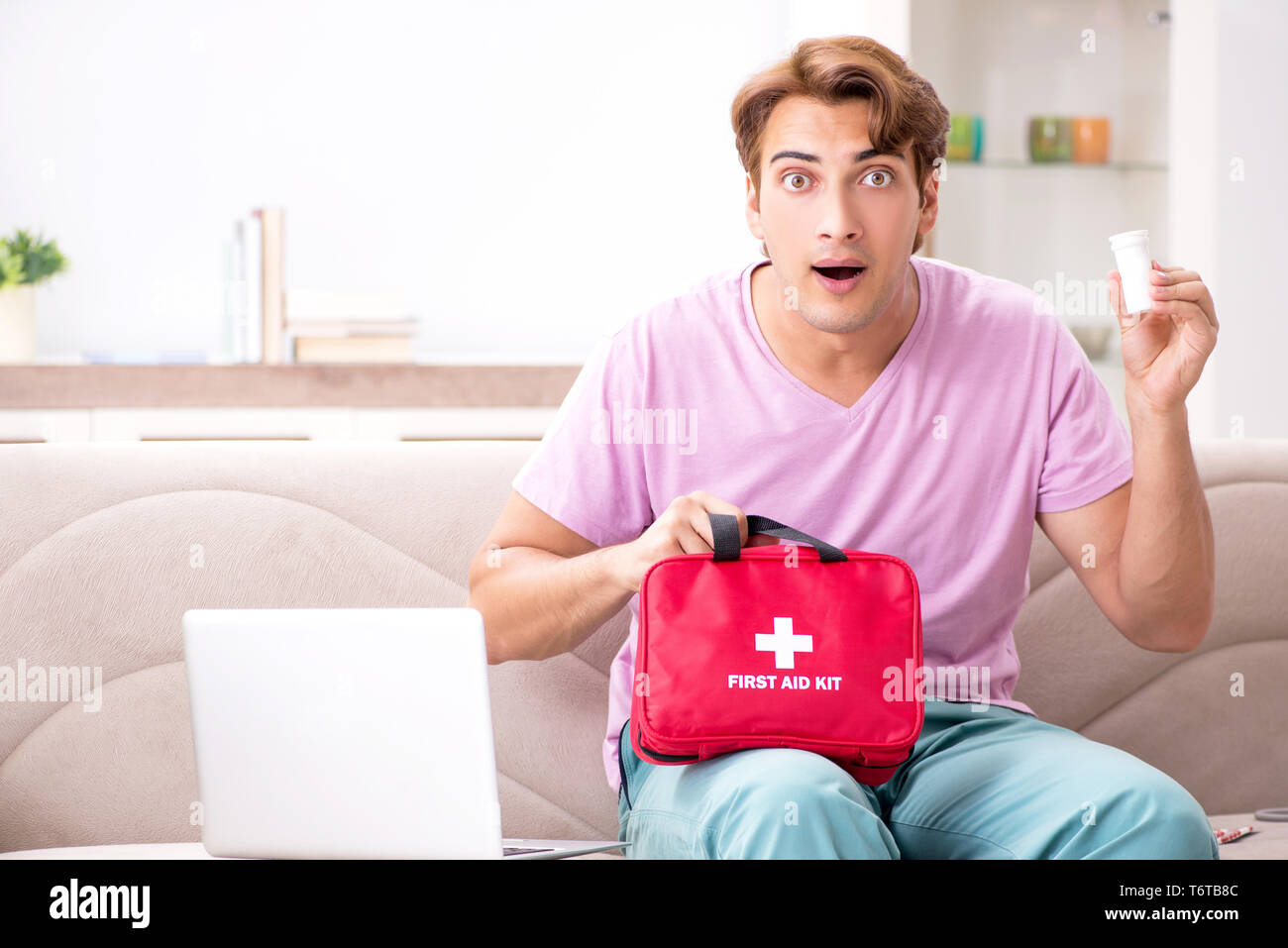 Sick man at home with first aid kit Stock Photo - Alamy