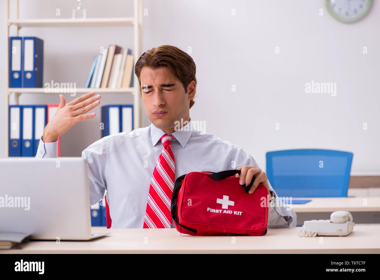 Man with first aid kit in the office Stock Photo - Alamy