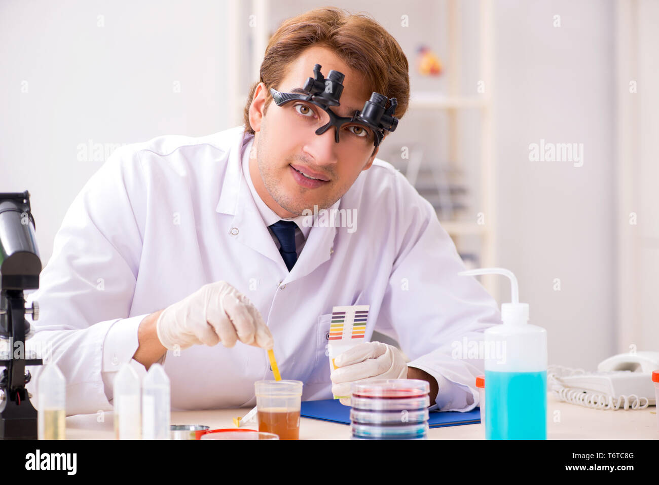 Chemist in the lab checking with ph strips Stock Photo - Alamy