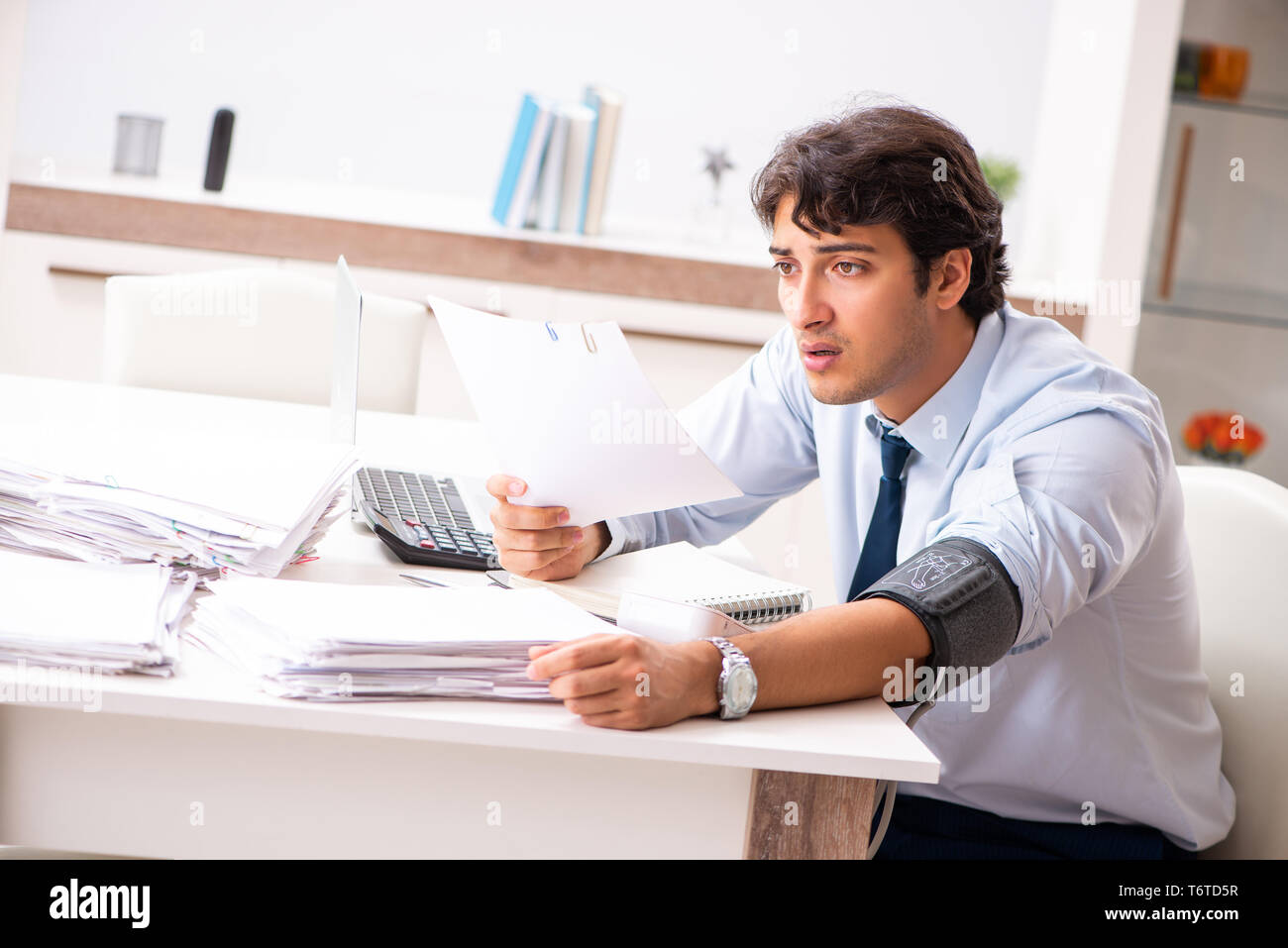 Man under stress measuring his blood pressure Stock Photo - Alamy