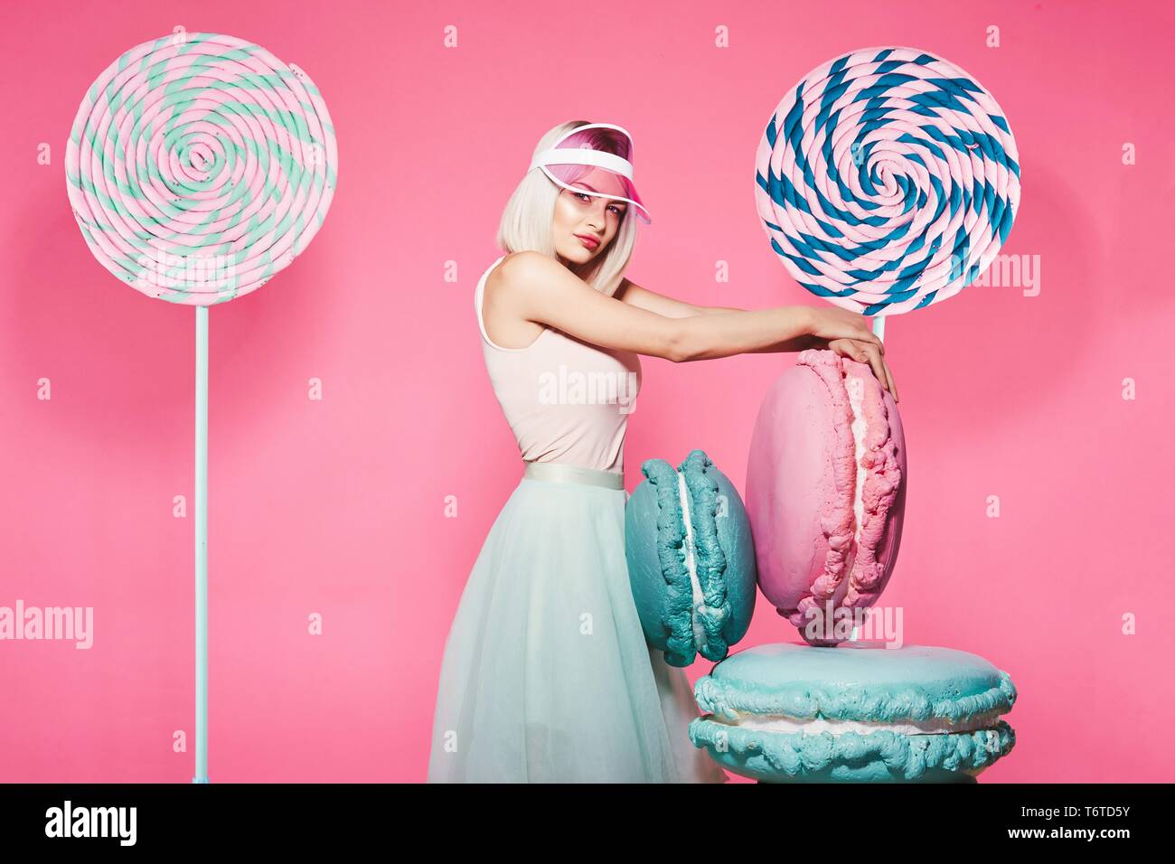 Beautiful girl posing with sweets at pink background Stock Photo - Alamy