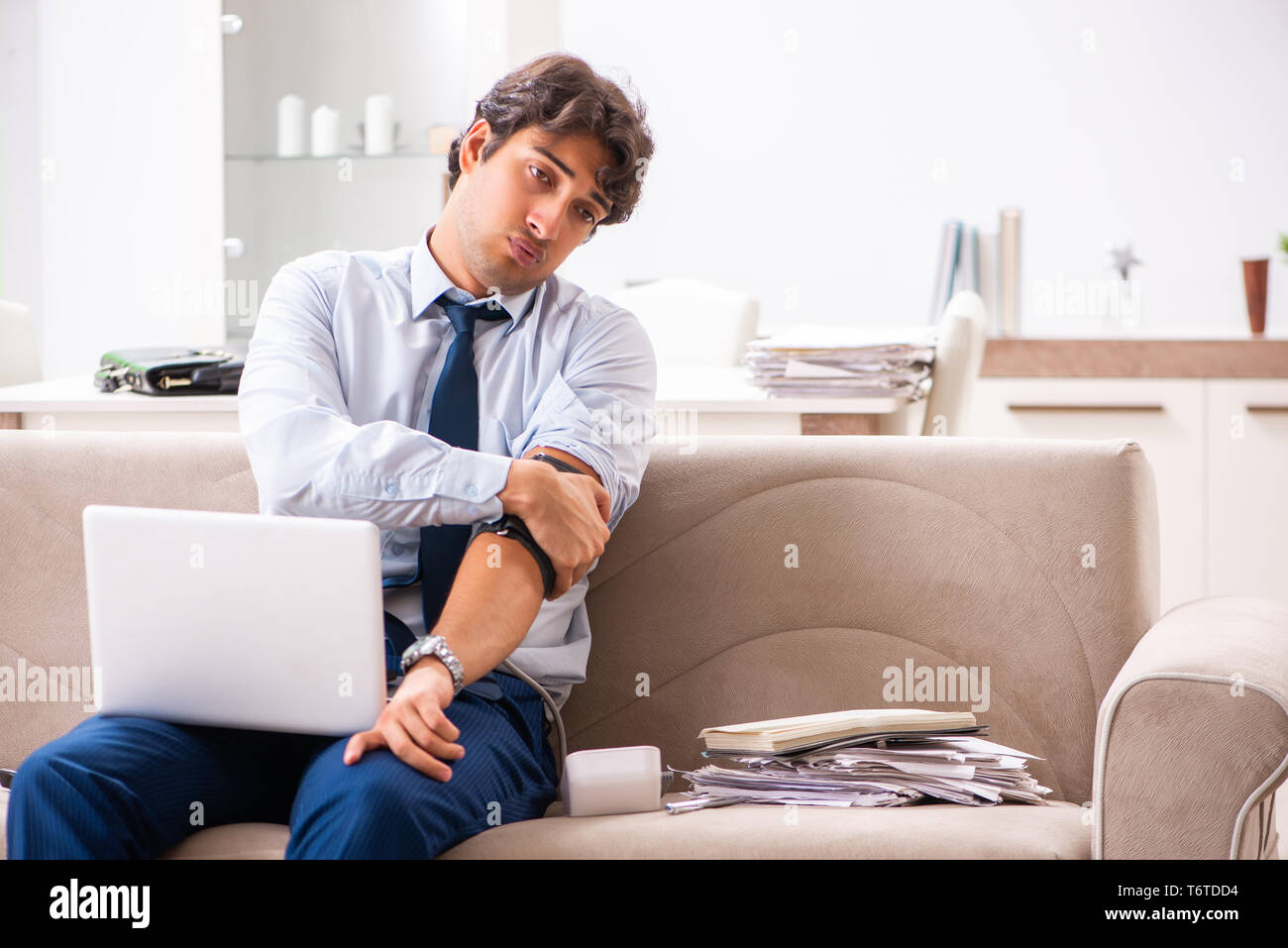 Man under stress measuring his blood pressure Stock Photo - Alamy