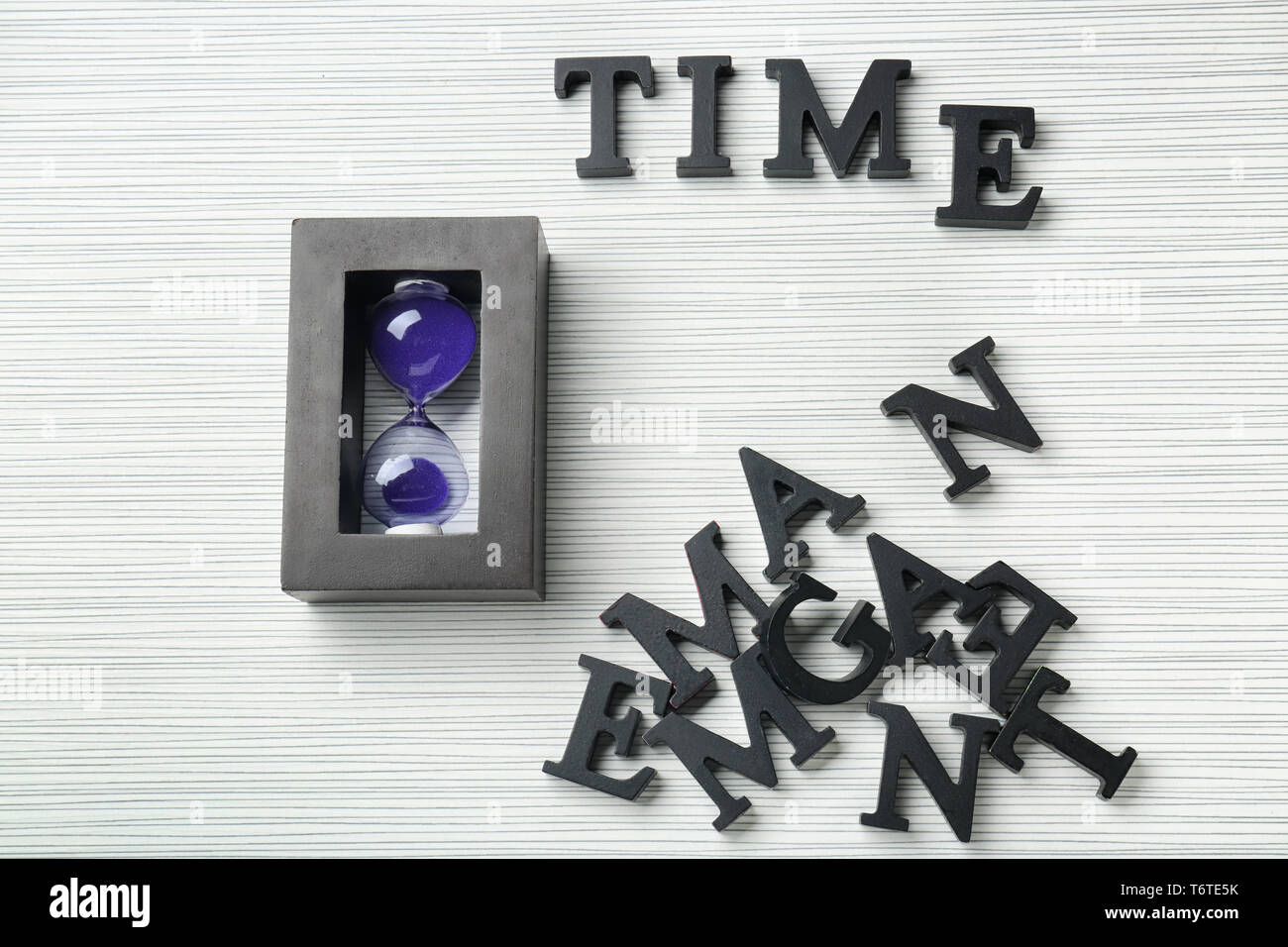 Hourglass and word "Time" composed from letters on table. Time ...