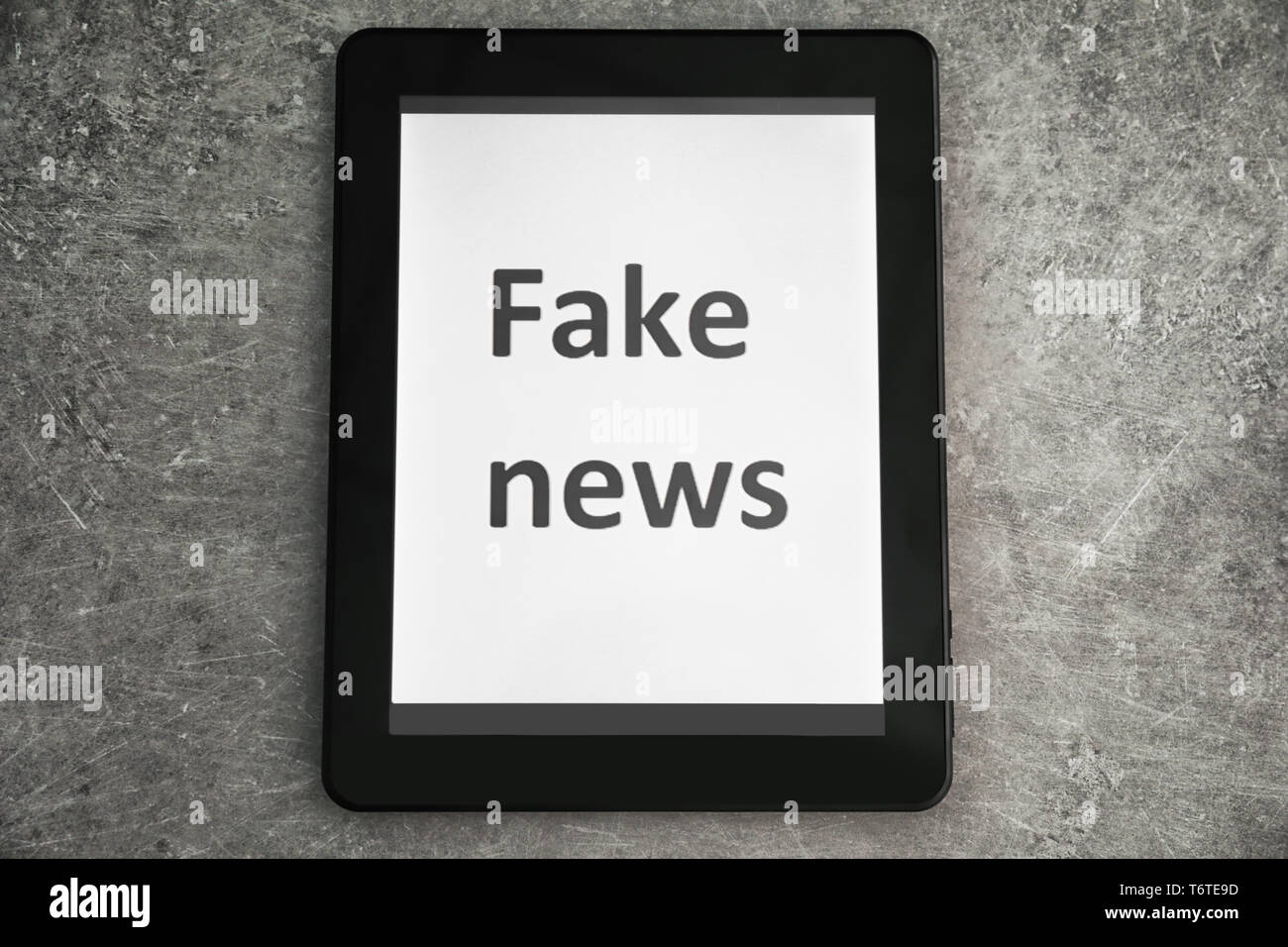 Tablet with text Fake NEWS on screen against grey background Stock ...