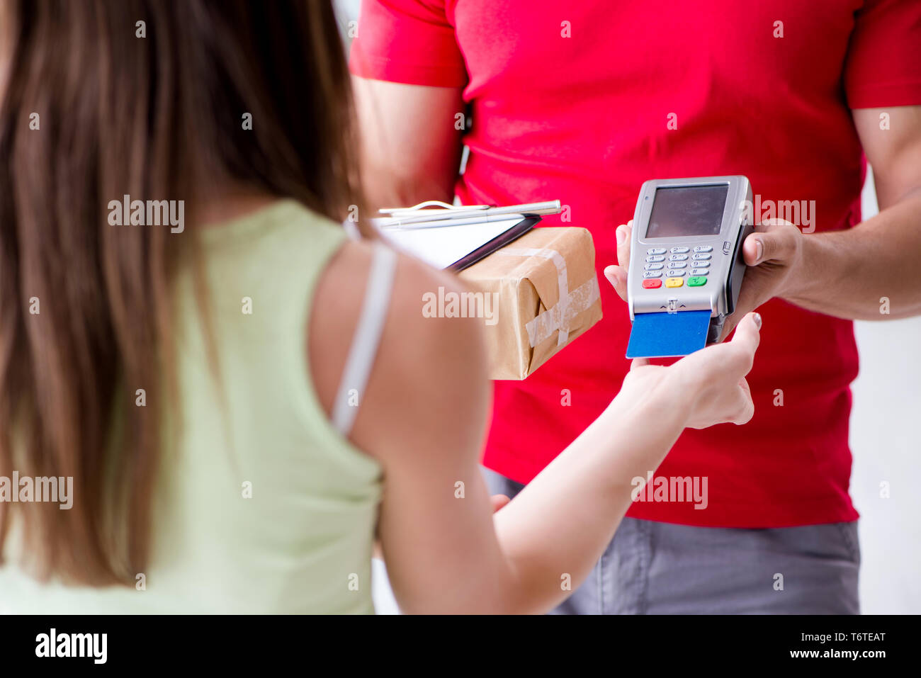 Parcel delivery being paid with pos and credit card Stock Photo - Alamy