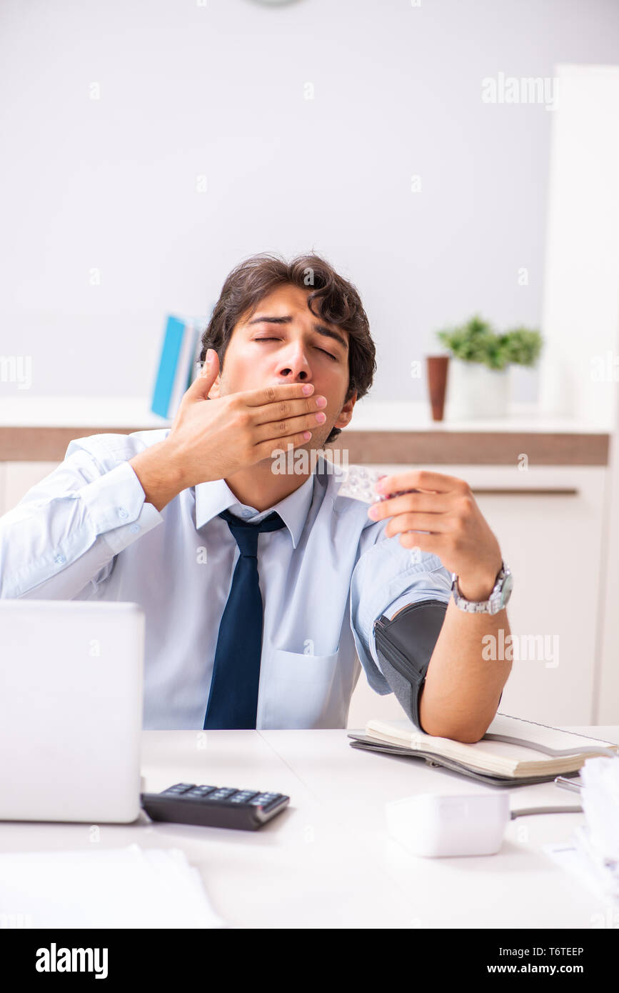 Man under stress measuring his blood pressure Stock Photo - Alamy