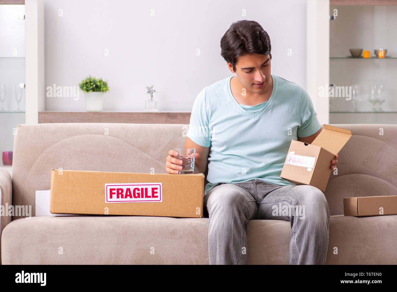 Man opening fragile parcel ordered from internet Stock Photo - Alamy