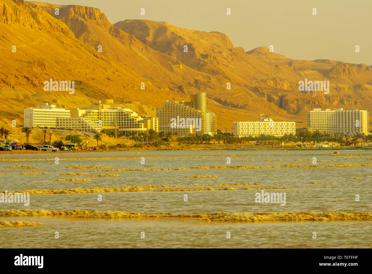 Sunrise view of salt formation in the Dead Sea, the Ein Bokek resort, and desert landscape ...