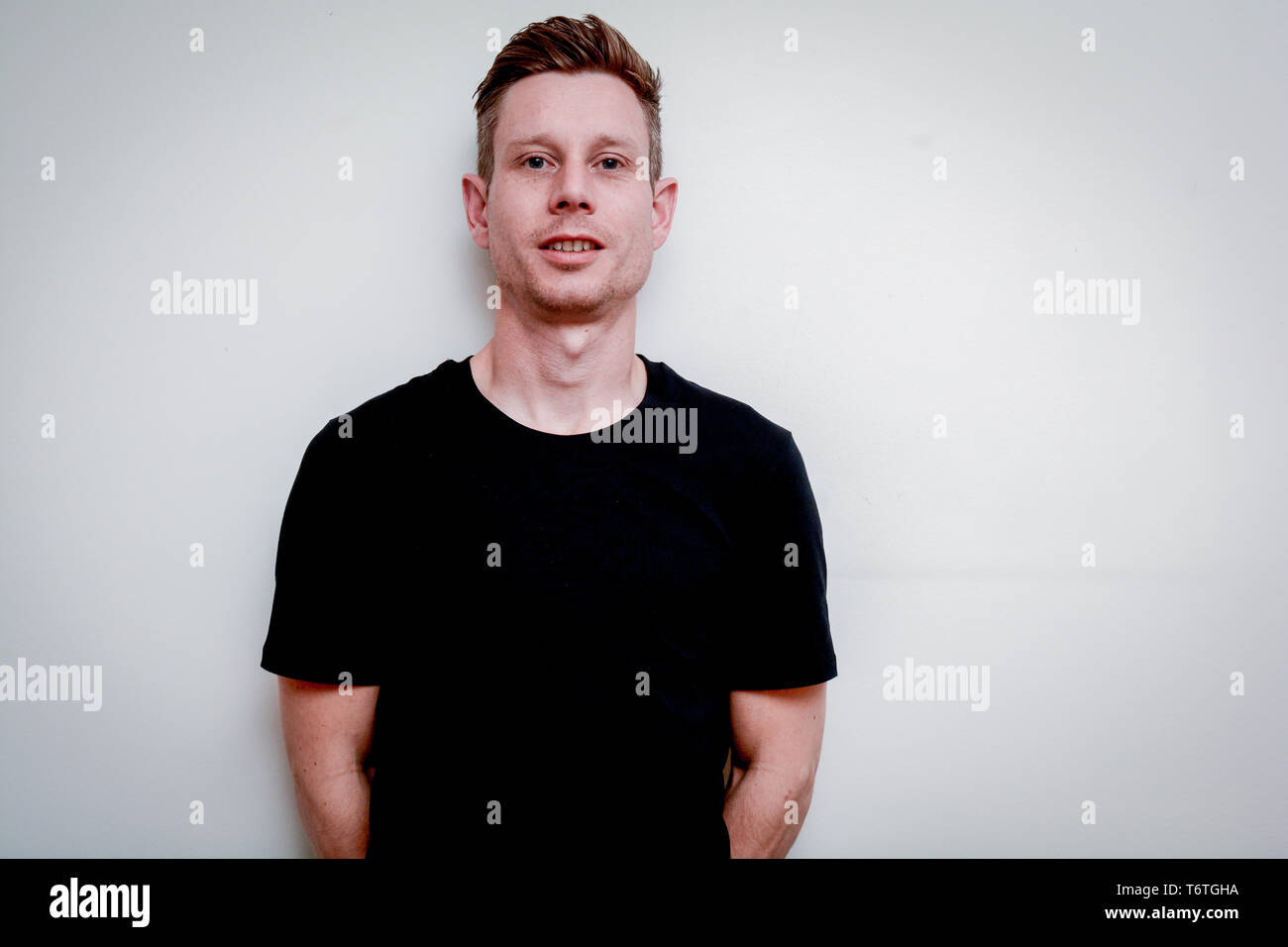 Man looking directly into camera, model looks happy and is smiling ...