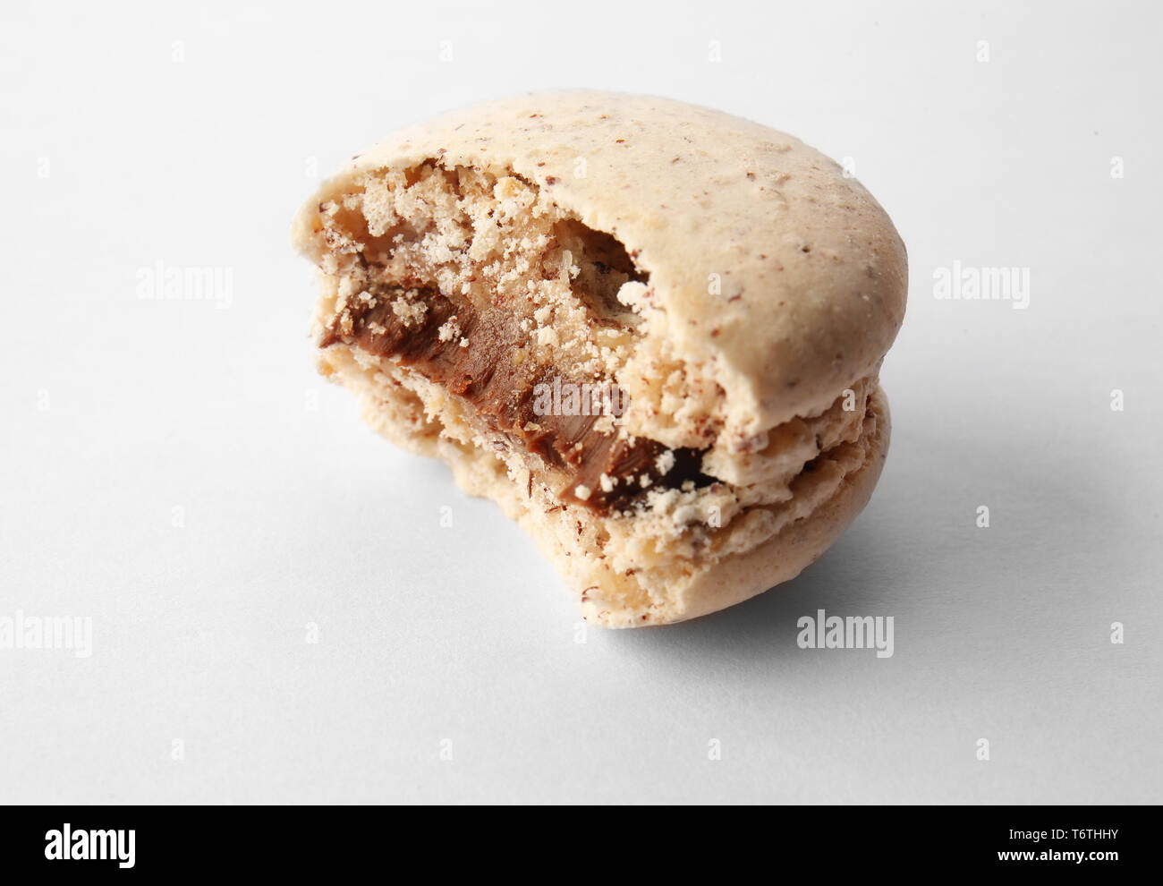 Tasty macaron with bite mark on white background Stock Photo - Alamy