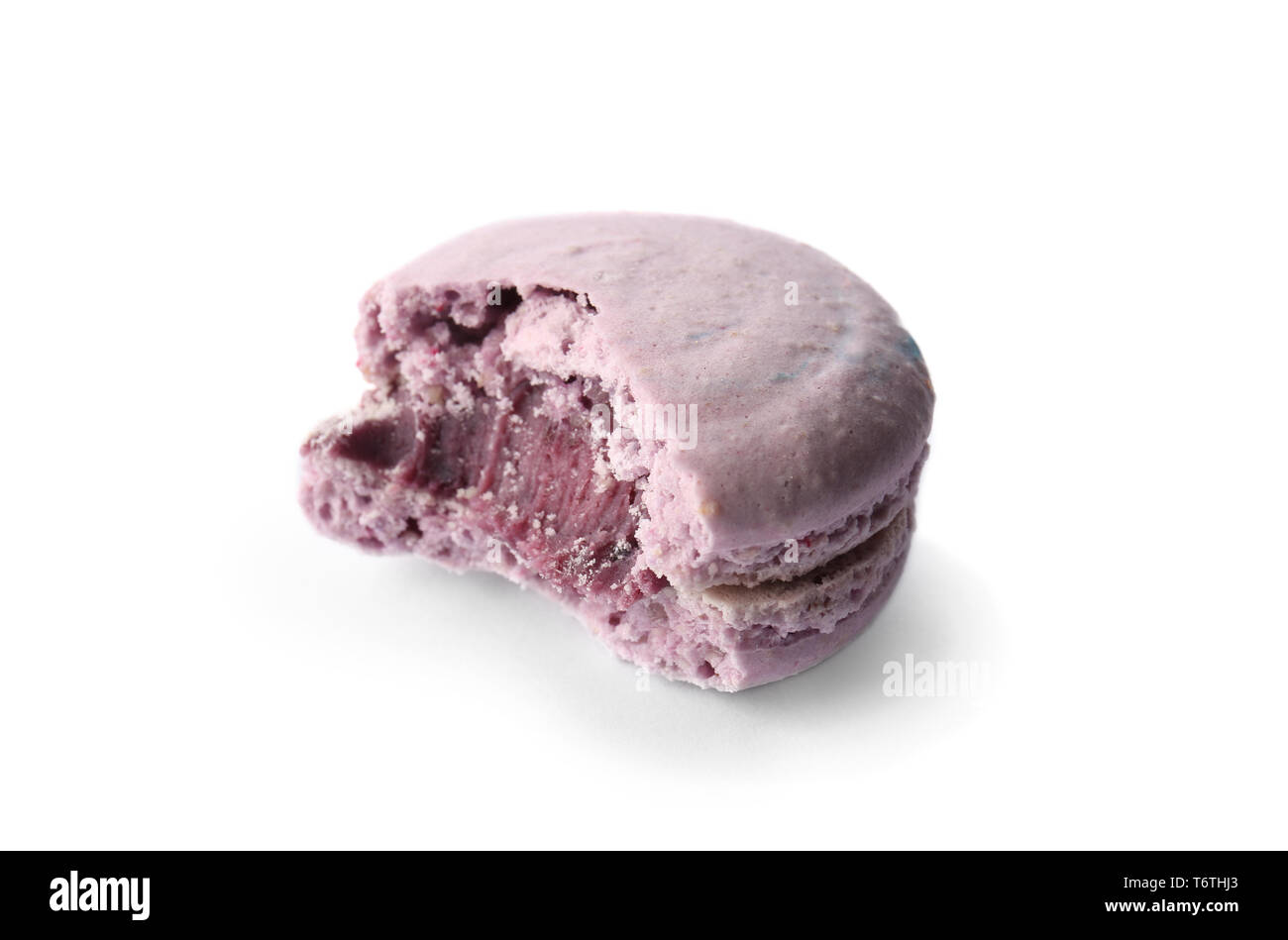 Tasty violet macaron with bite mark on white background Stock Photo - Alamy