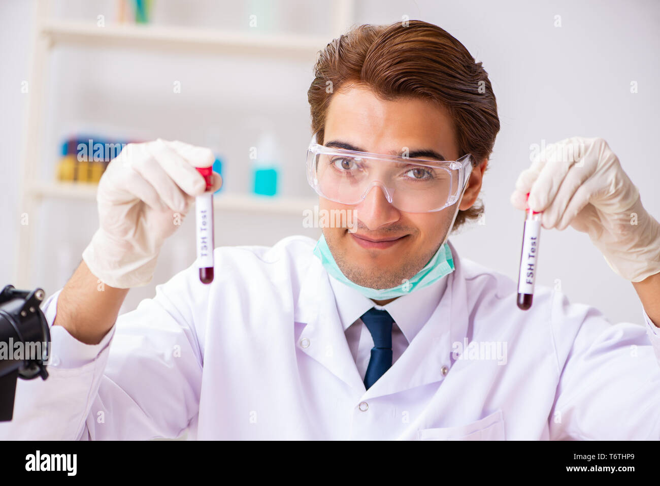 Young handsome lab assistant testing blood samples in hospital Stock ...