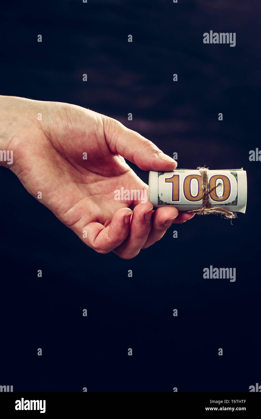 A woman's hand holding 100 hundred banknotes, a money transfer, a dark ...