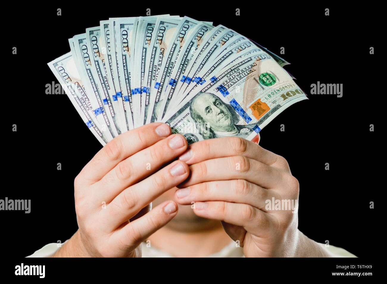 Close up of a businessman's hands holding money over a black background ...