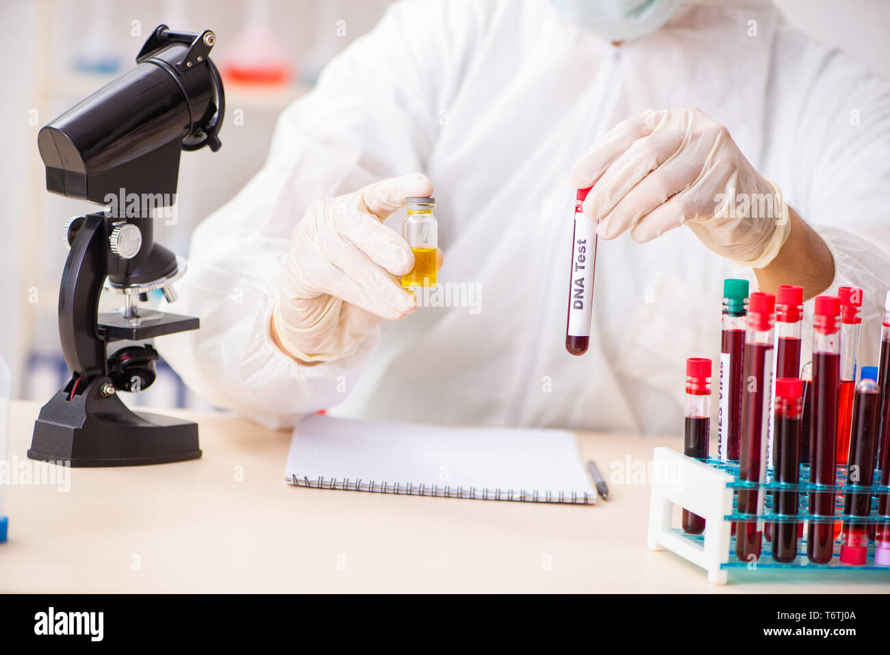 Young handsome lab assistant testing blood samples in hospital Stock ...