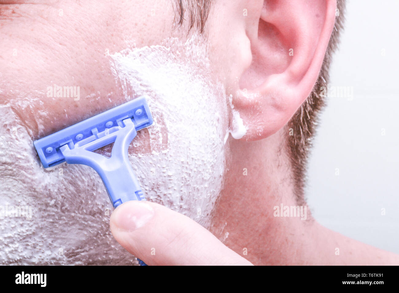 Close up of man shaving in mirror as part of daily skin care routine ...