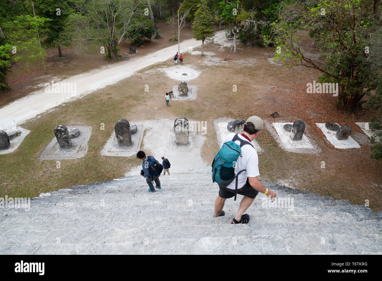 Tikal tourists - people climbing down one of the temples at Complex Q ...