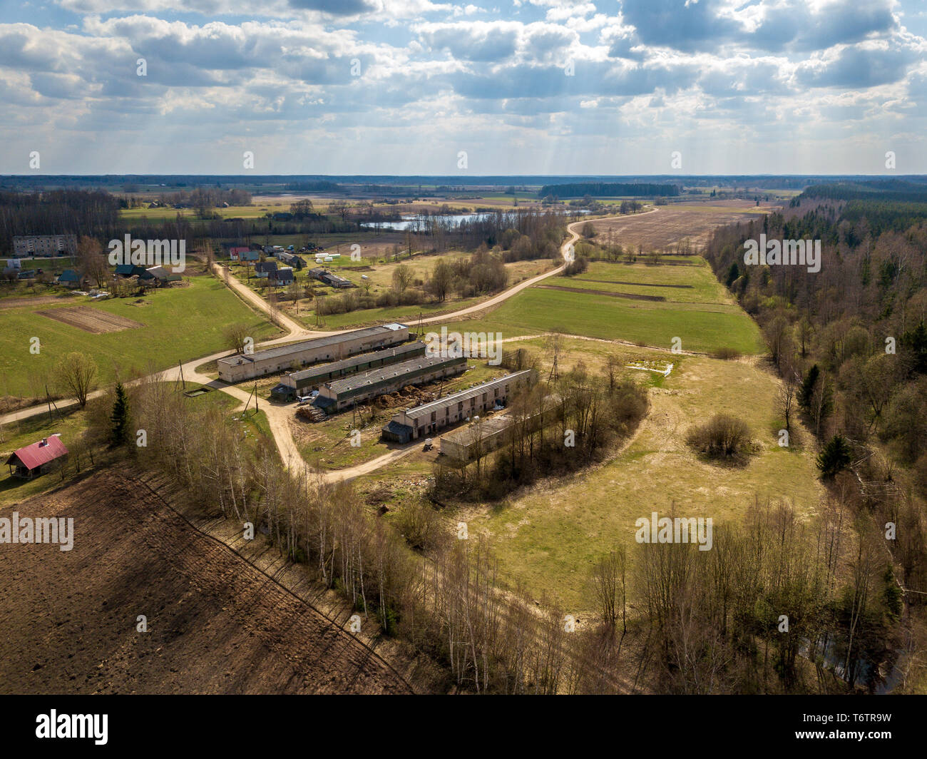 aerial view of country roads and small village with houses and lake ...
