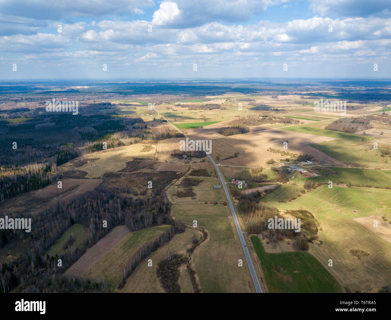 aerial view of country roads and small village with houses and lake ...