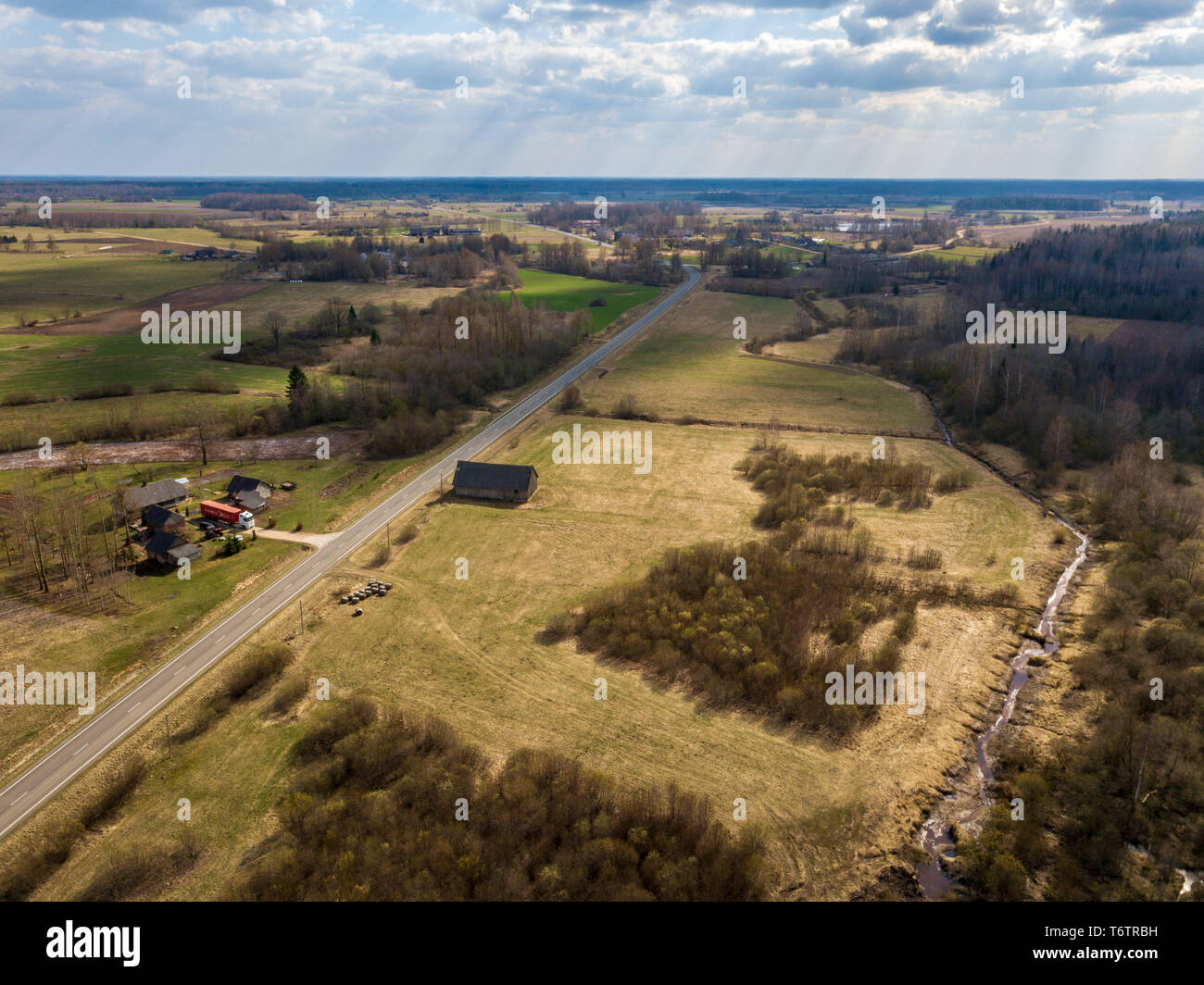 aerial view of country roads and small village with houses and lake ...