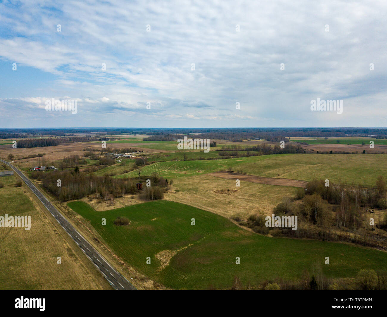 aerial view of country roads and small village with houses and lake ...