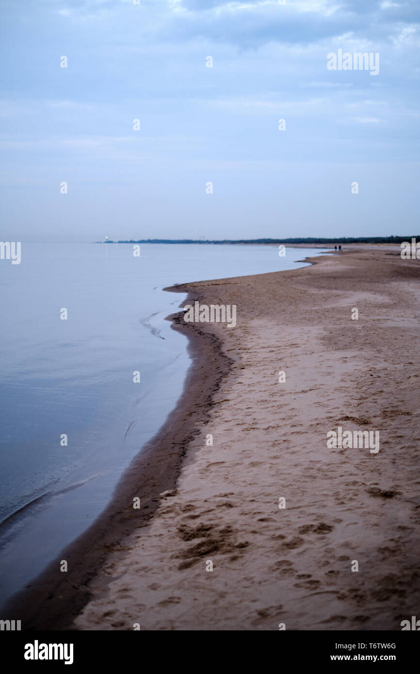 calm sea beach on the shore of Baltic sea with blue clouds and low tide ...