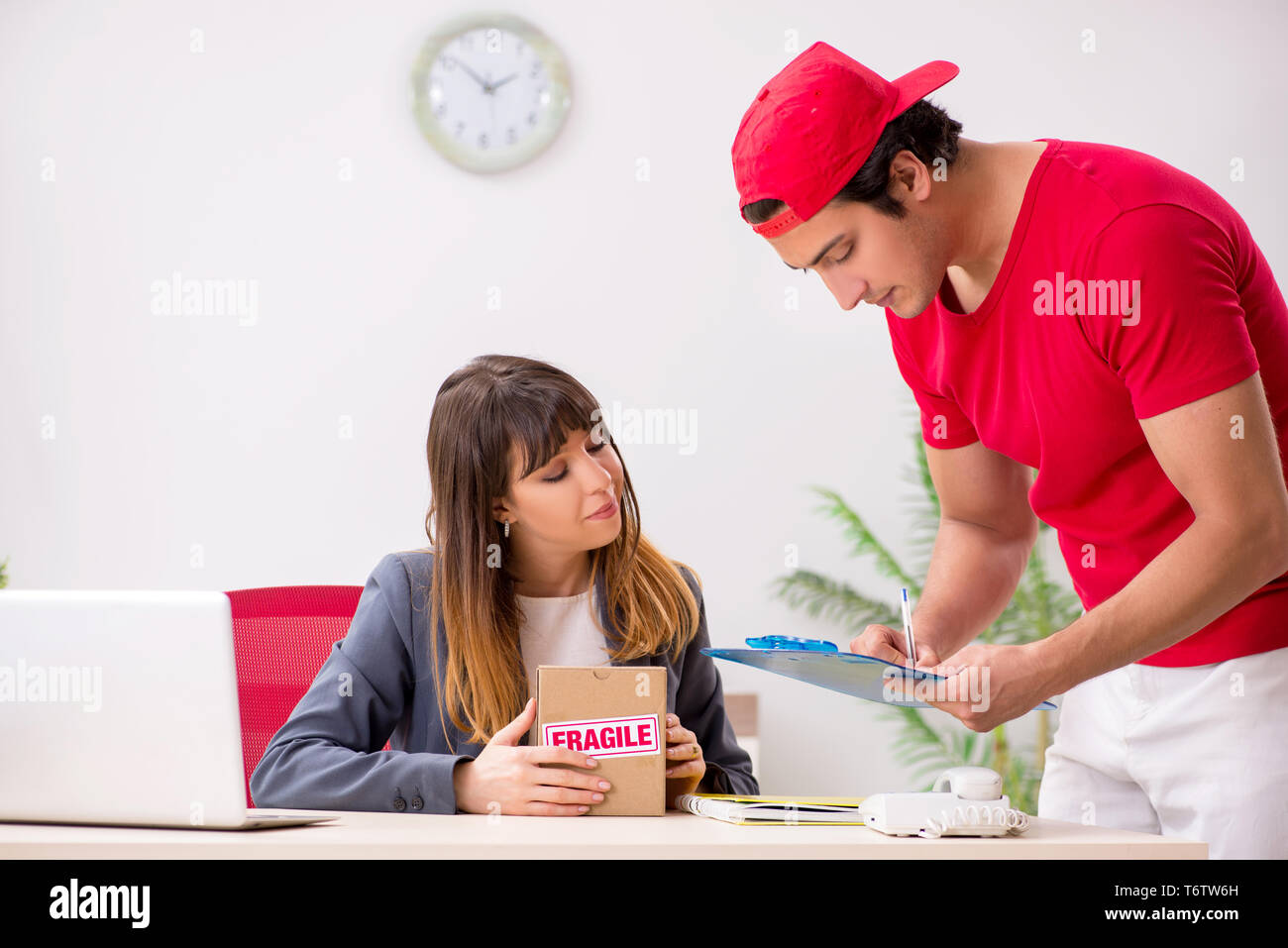 Courier delivering parcel to the office Stock Photo - Alamy