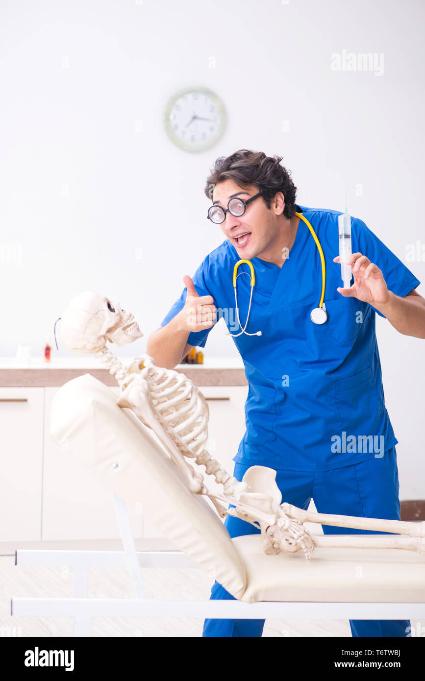 Funny doctor with skeleton in hospital Stock Photo - Alamy