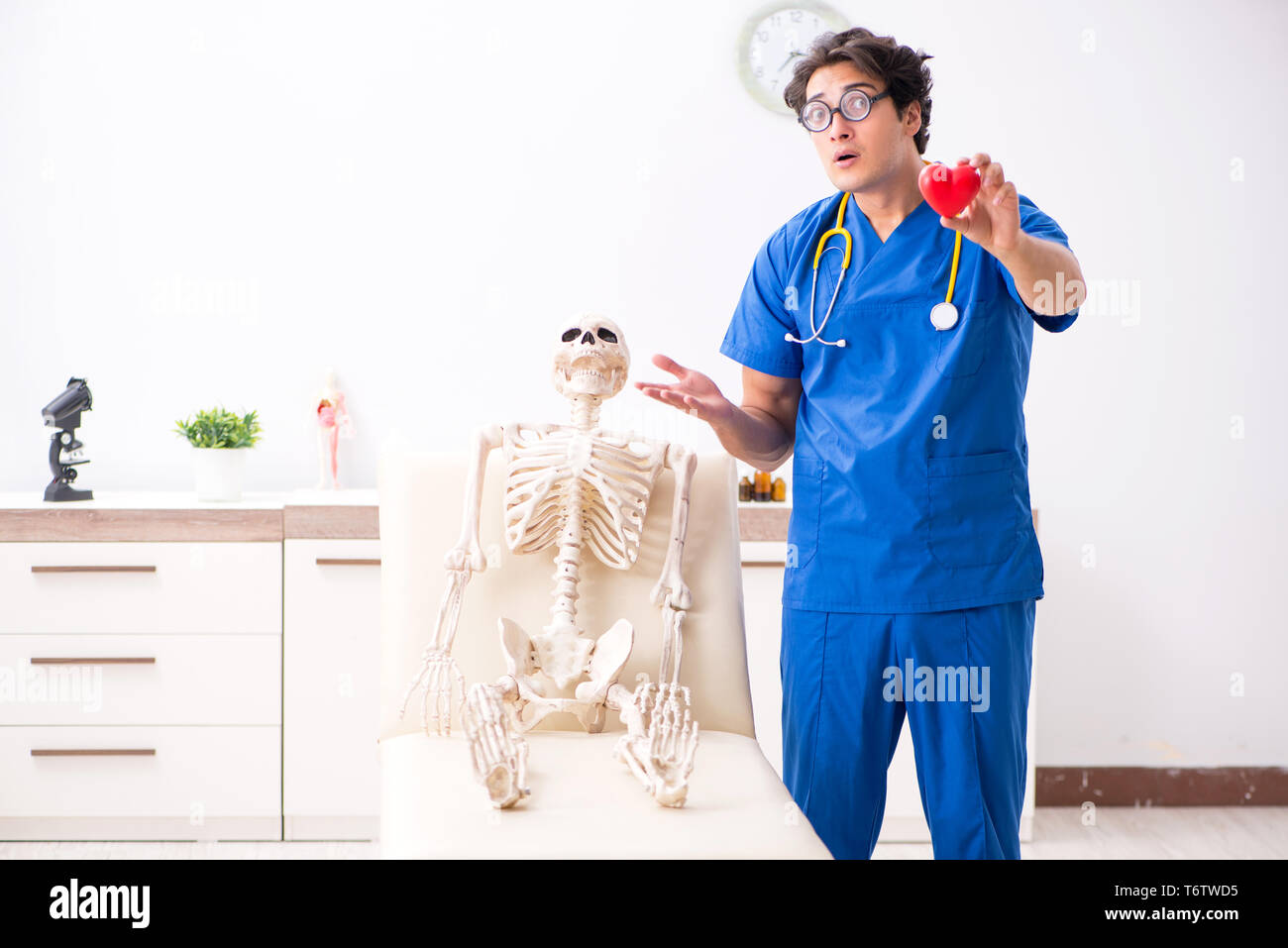 Funny doctor with skeleton in hospital Stock Photo - Alamy