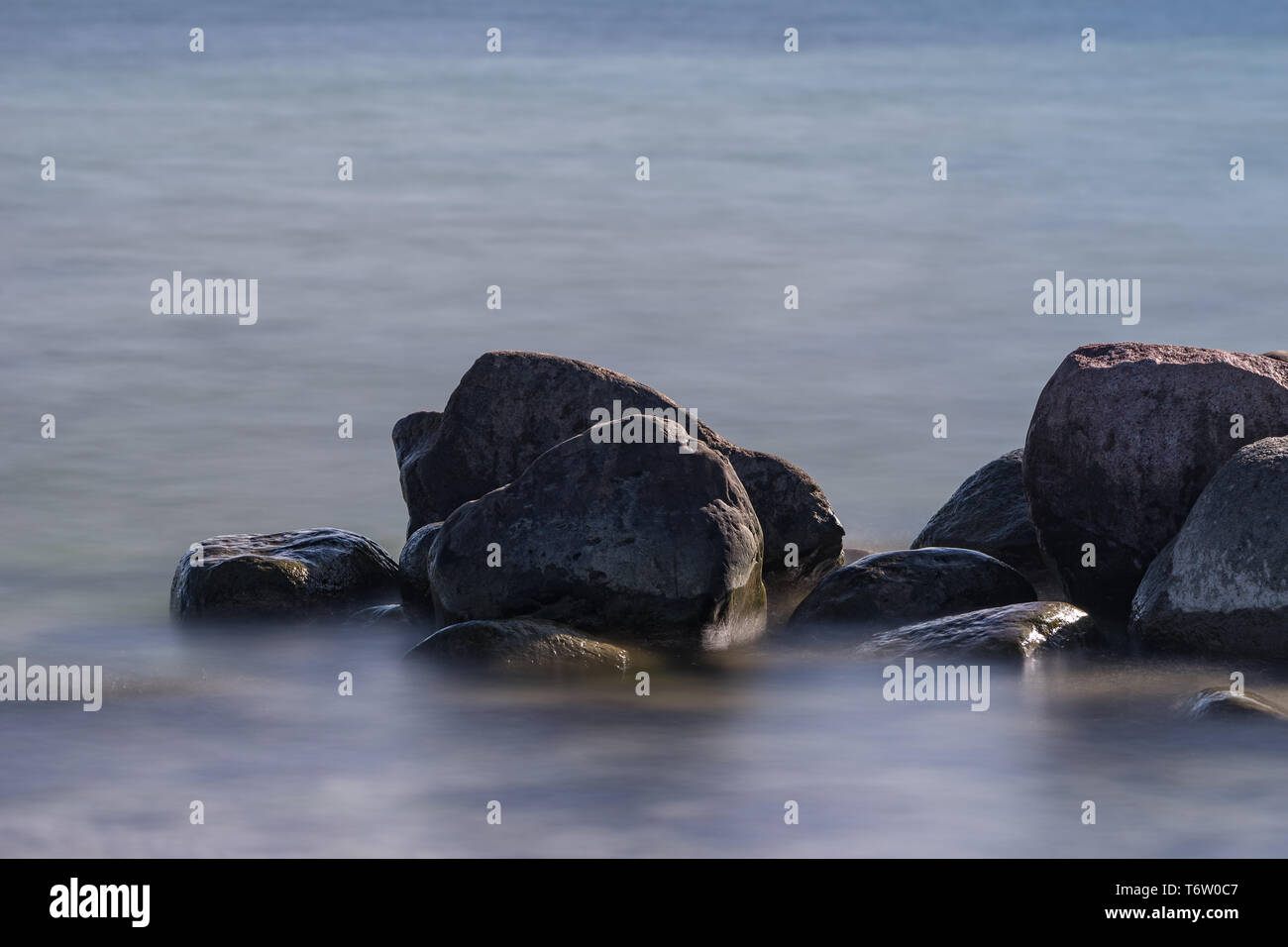 Calm blue see and big stones on the beachbeach Stock Photo - Alamy