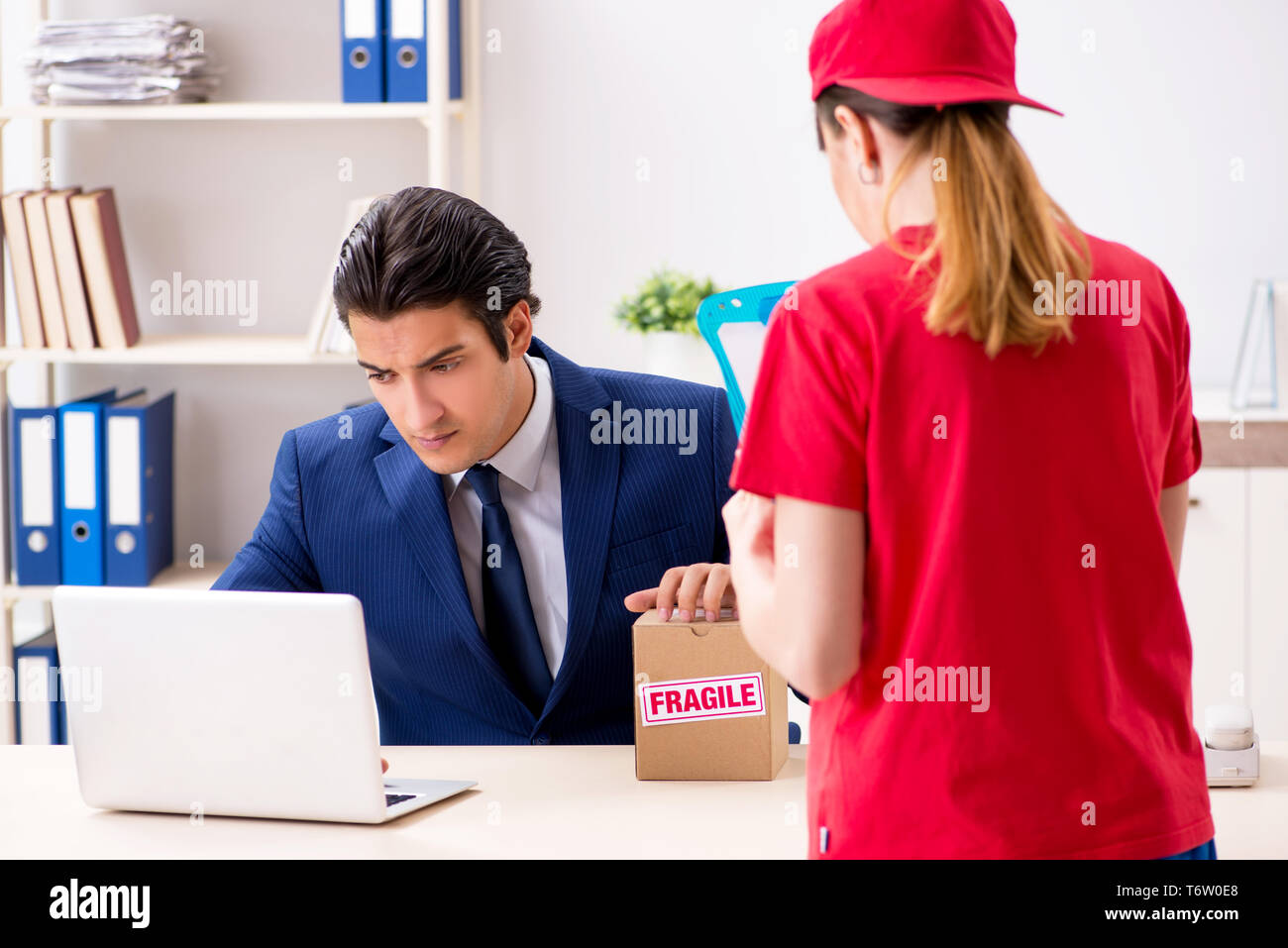 Courier delivering parcel to the office Stock Photo - Alamy