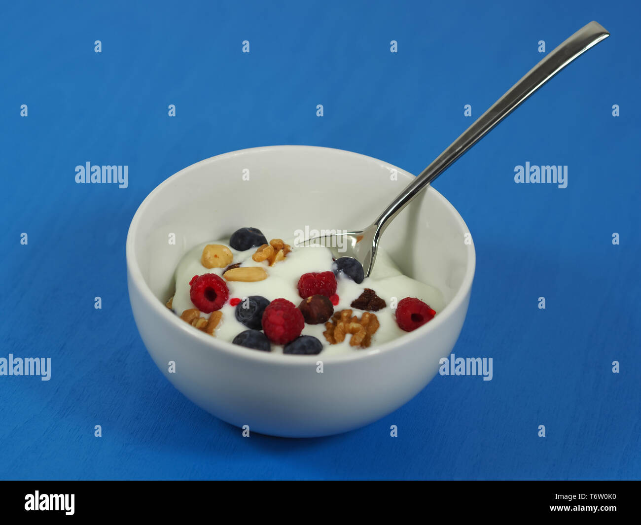 Different kinds of fresh fruits with yoghurt with blue background Stock ...