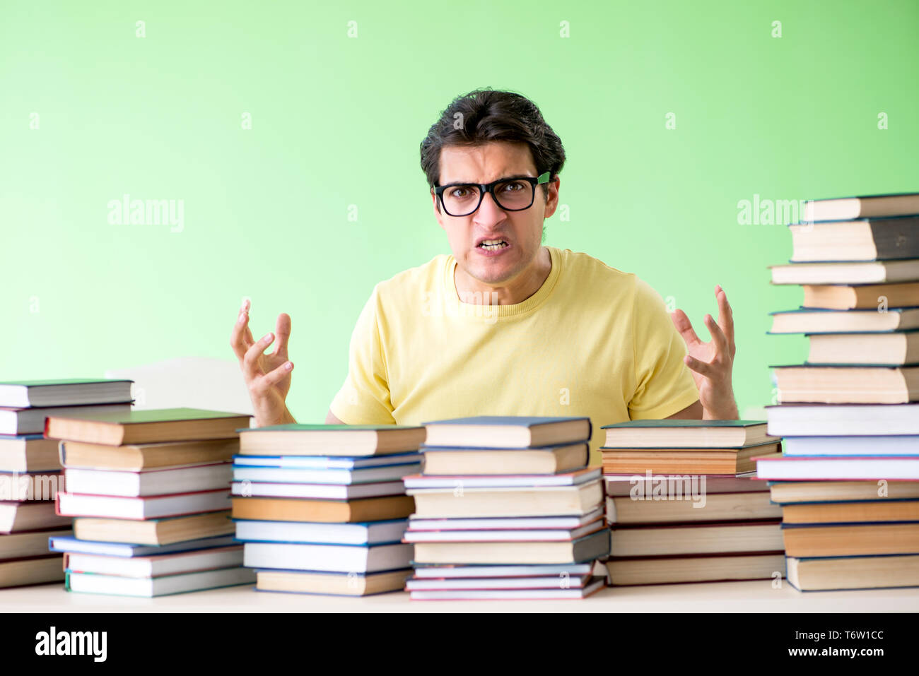 Student with too many books to read before exam Stock Photo - Alamy