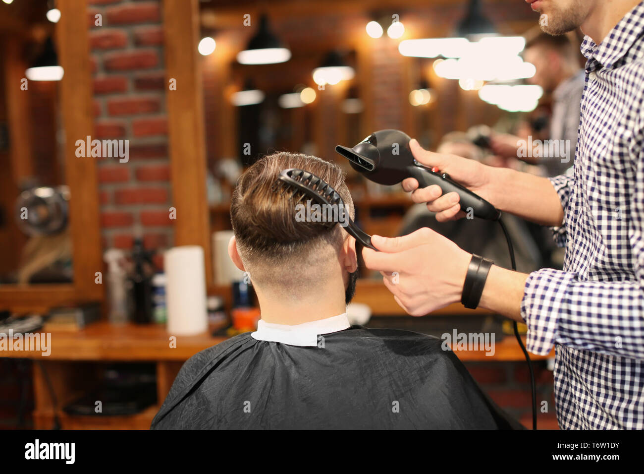Professional barber working with client in hairdressing salon Stock ...