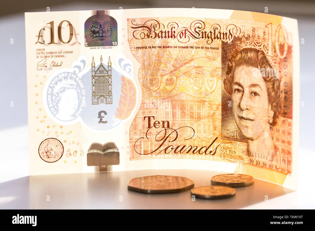 Close-up photo of a piece of new £10 banknote and pence coins. Ten ...