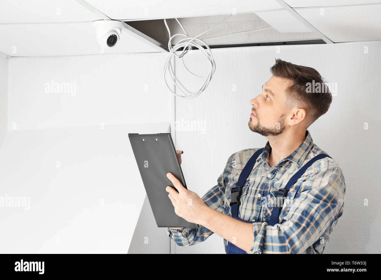 Electrician inspecting surveillance camera Stock Photo - Alamy