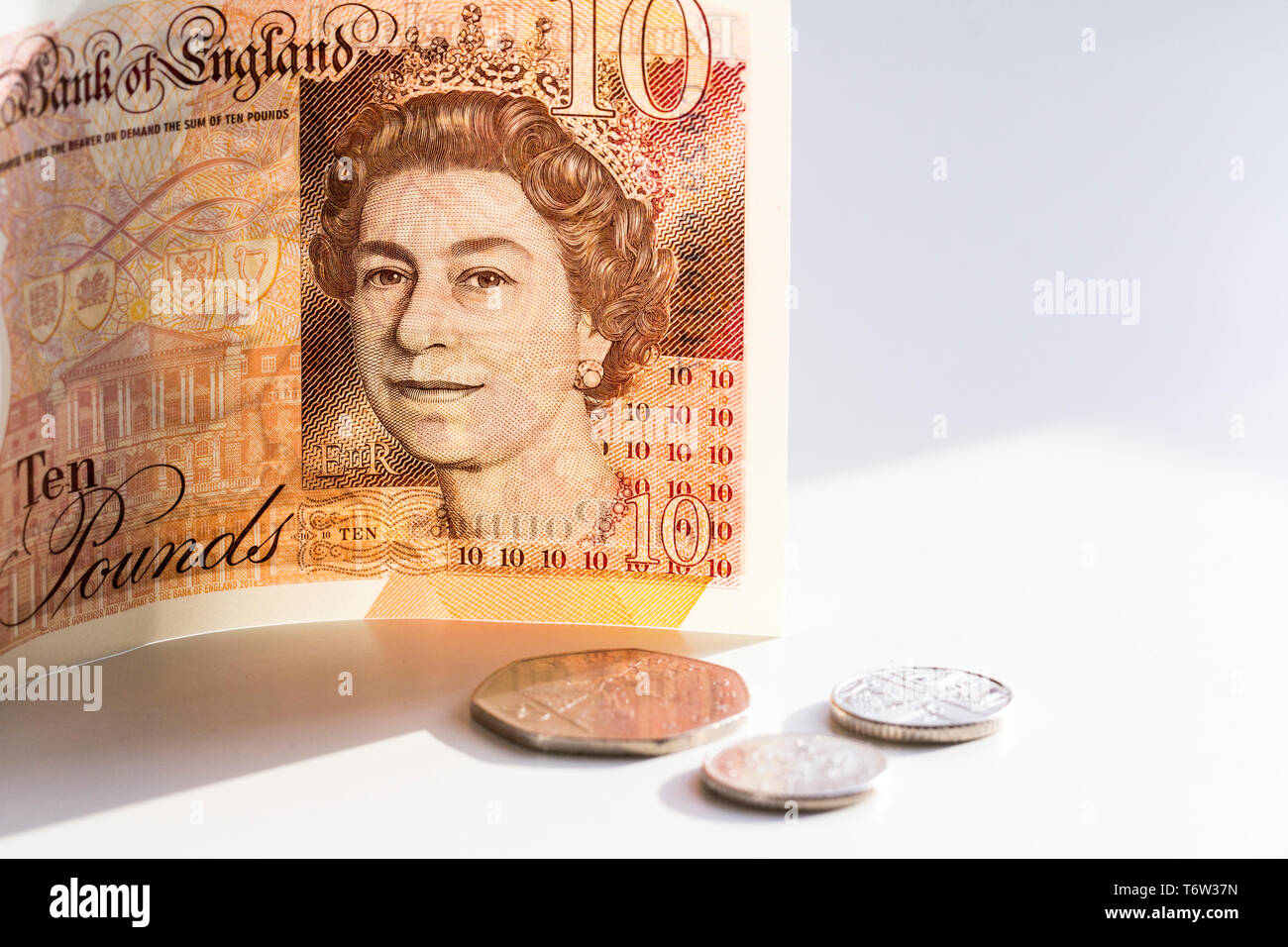 Close-up photo of a piece of new £10 banknote and pence coins. Ten ...