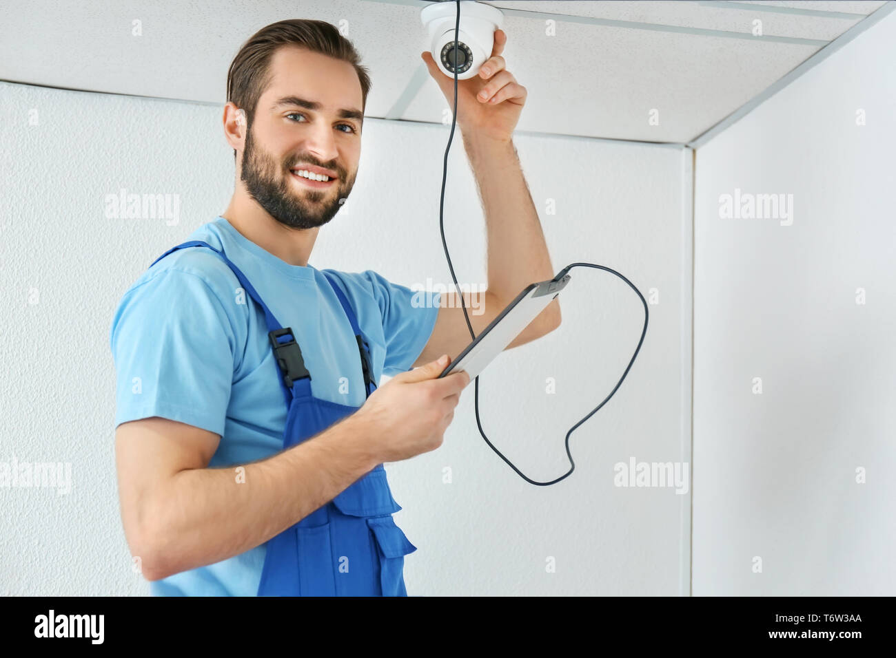 Electrician inspecting surveillance camera Stock Photo - Alamy