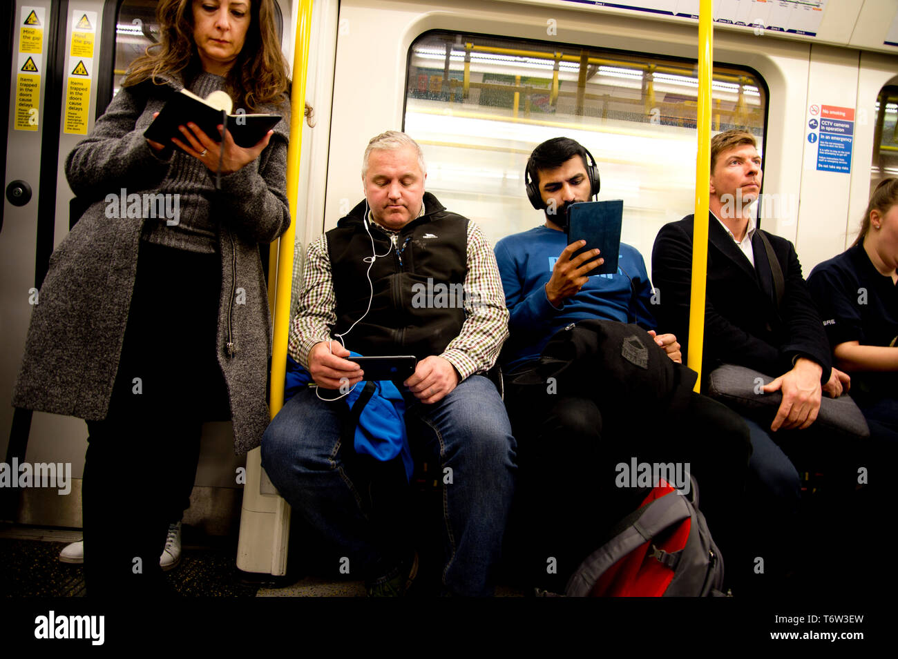 District Line, London Underground. May 1st 2019. Passengers read mobile ...