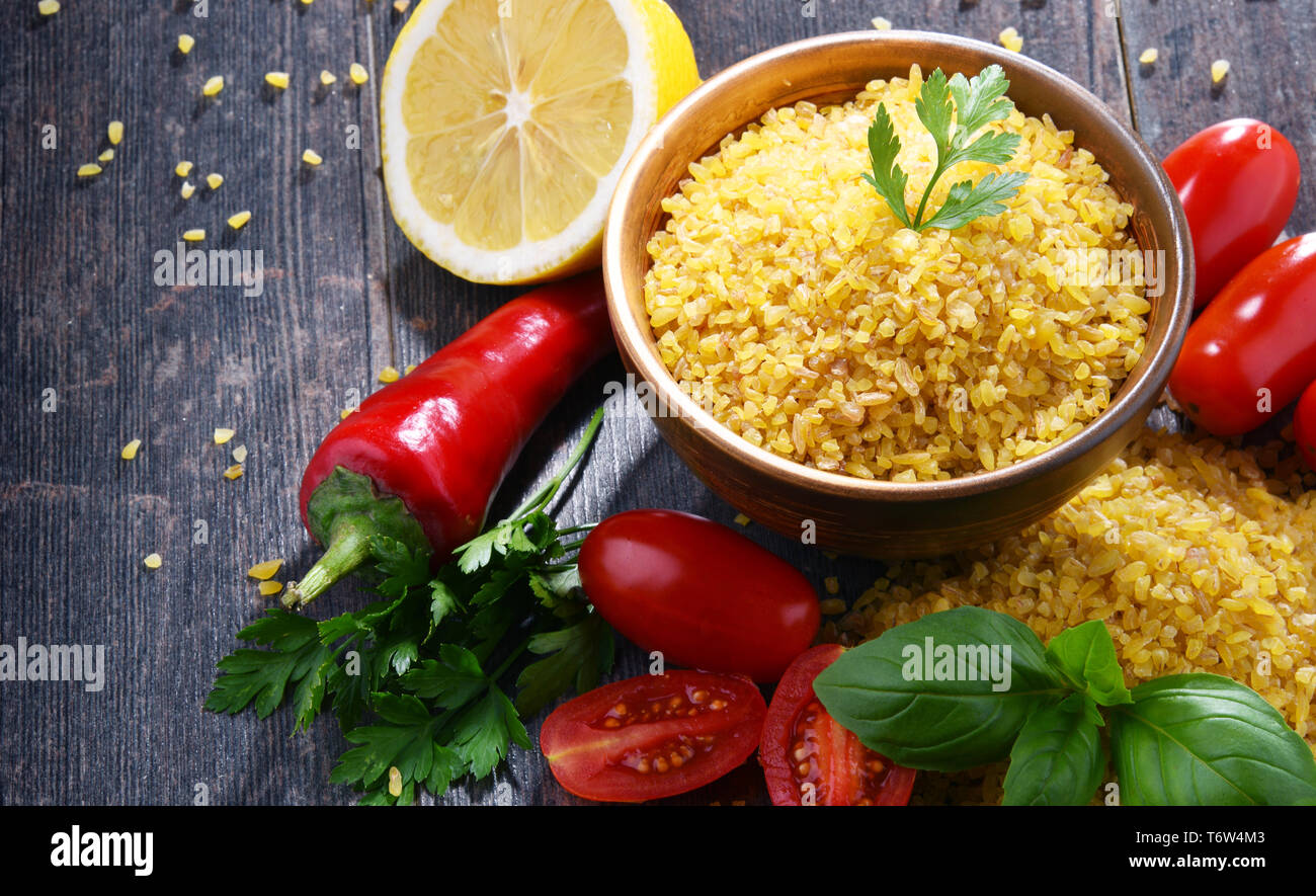 Bowl of uncooked bulgur on wooden table Stock Photo - Alamy