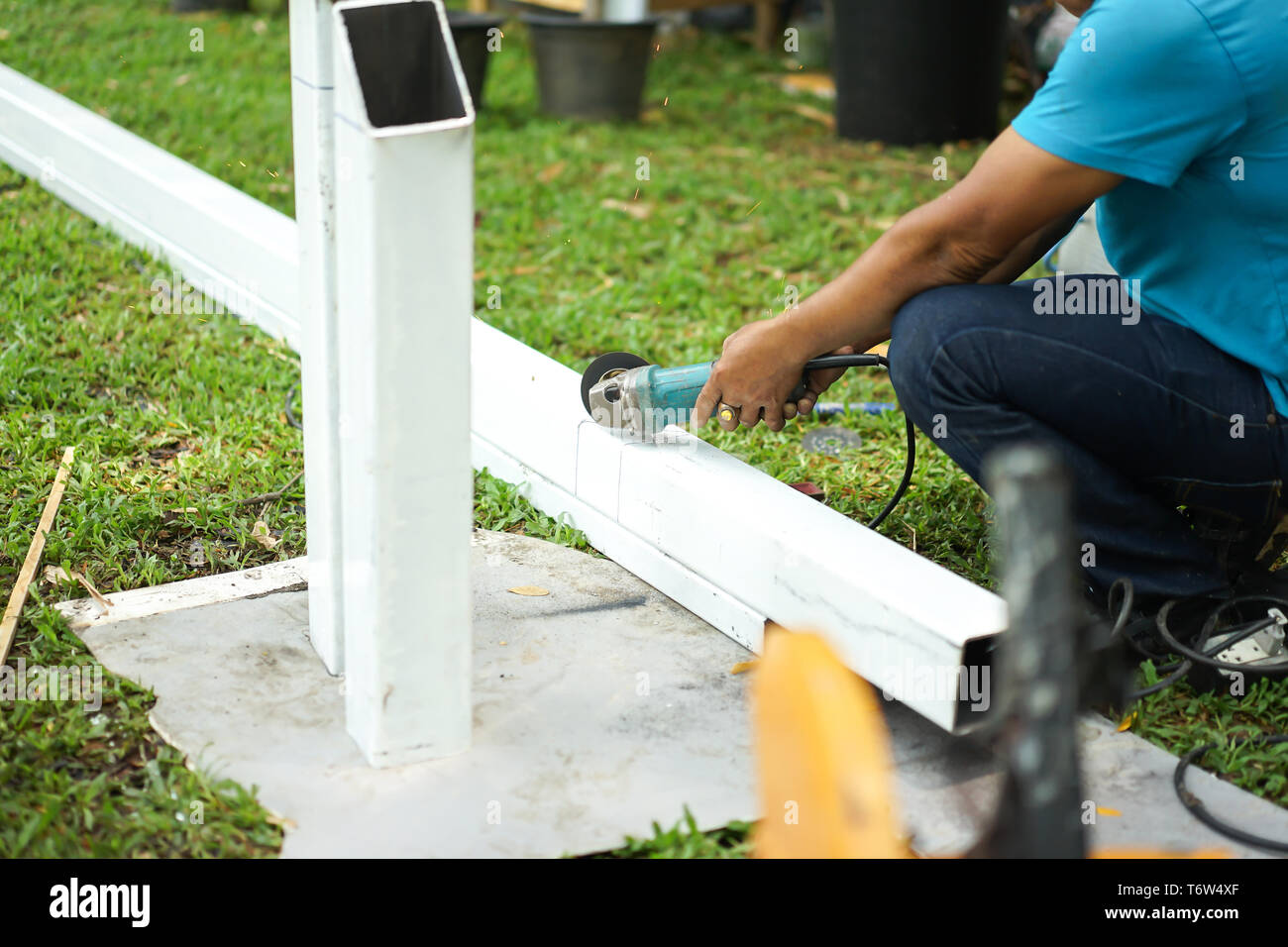 Asian smith worker are sawing the steel / iron pole in the backyard ...