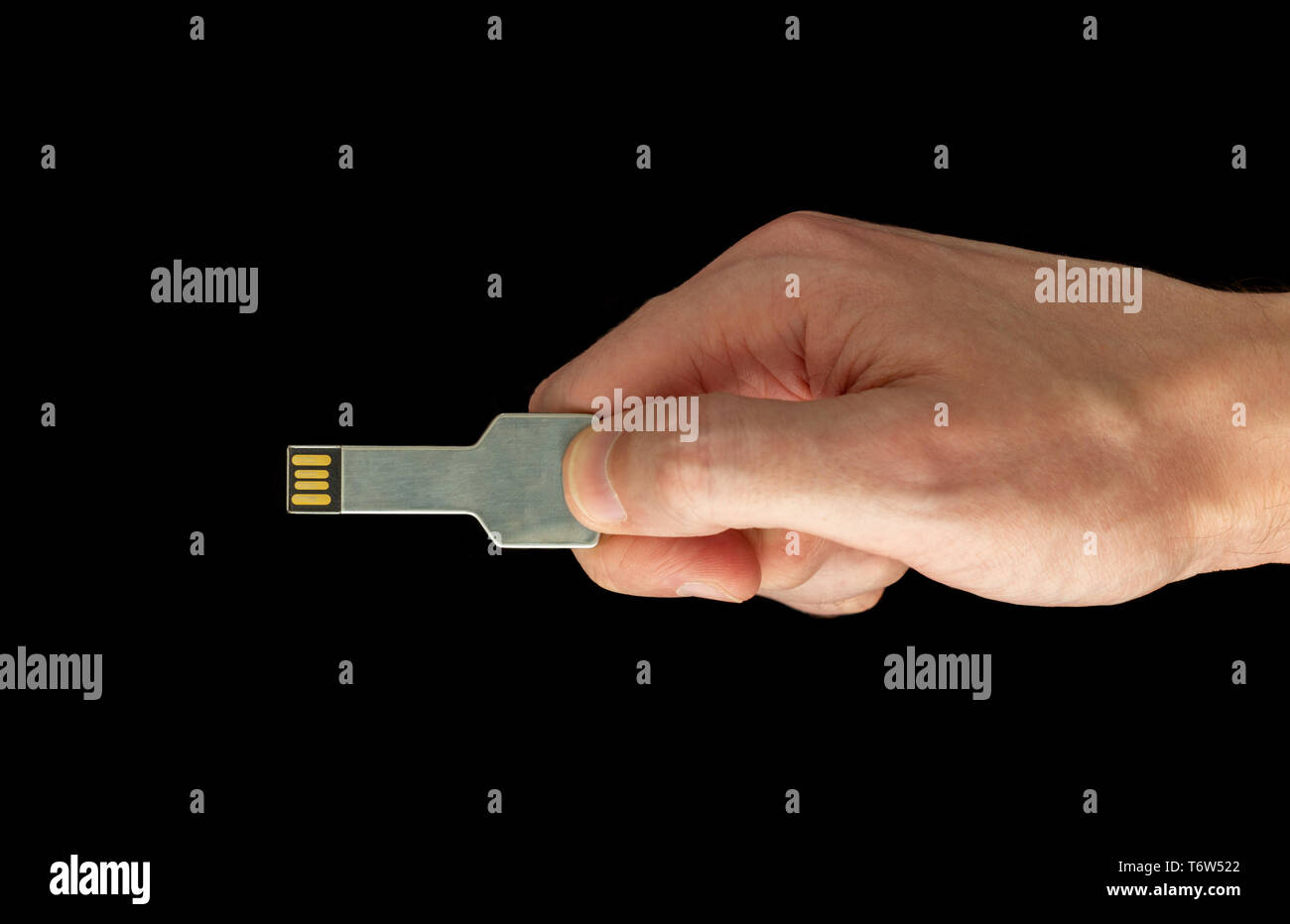 USB Flash Drive Disk shaped like a key in hand on isolated black ...