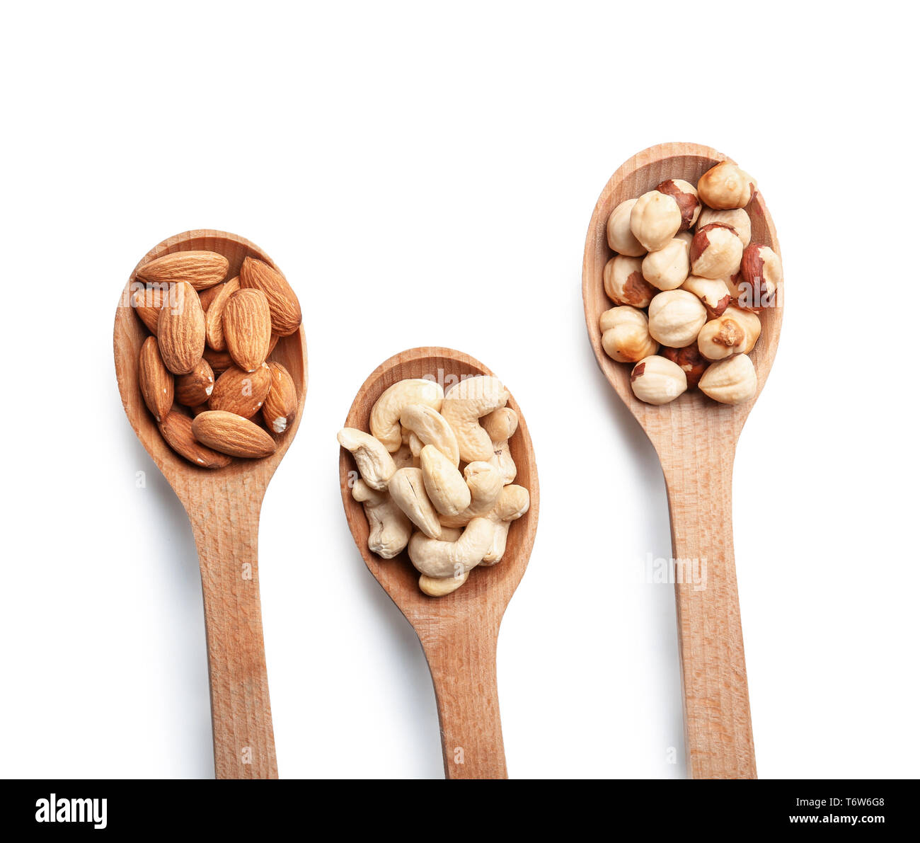 Spoons with different nuts on white background Stock Photo - Alamy