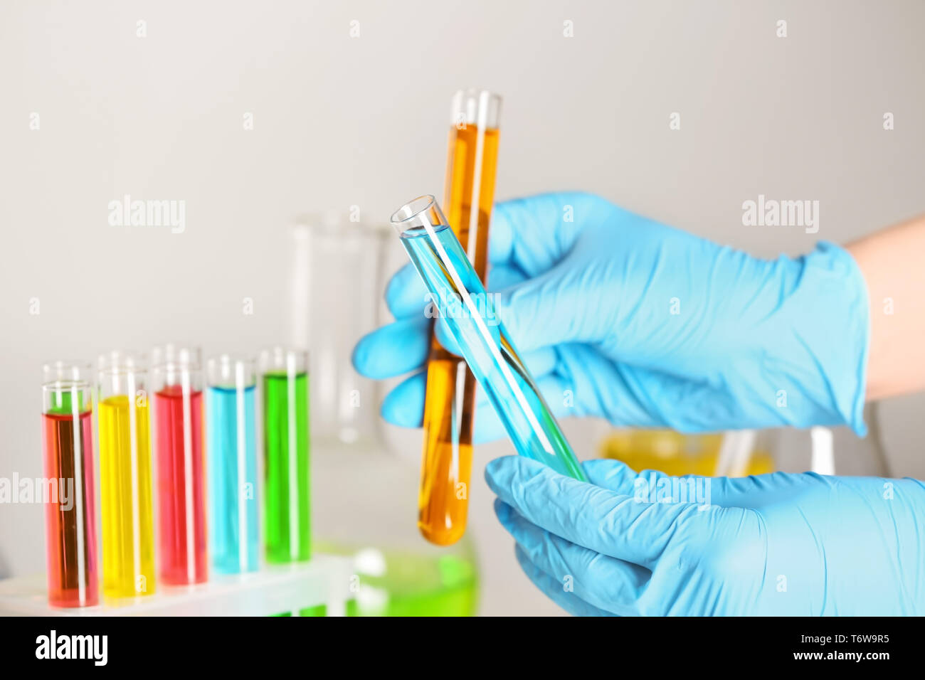 Laboratory worker holding test tubes with colorful liquids, closeup ...