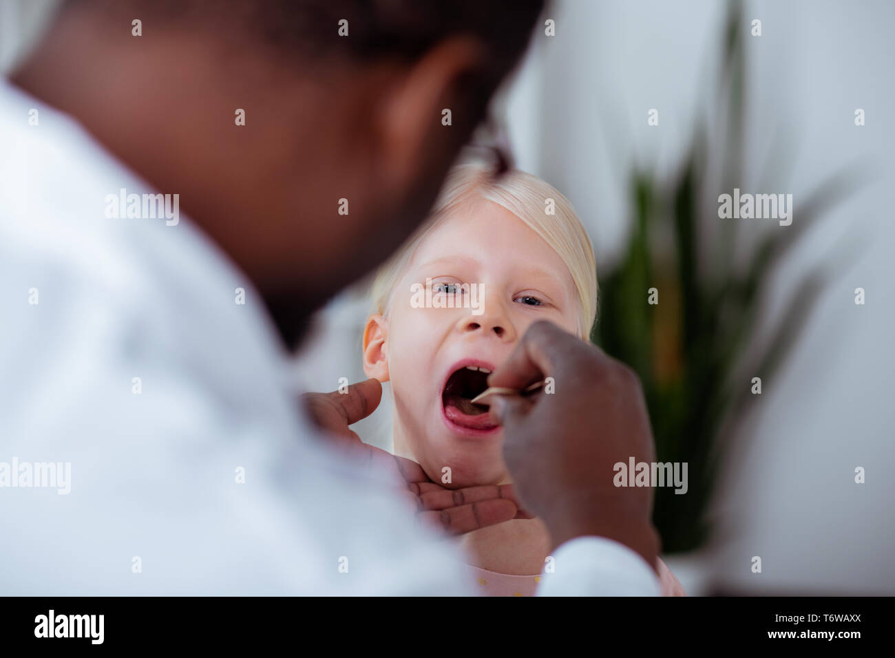 Close up of blonde girl opening mouth while coming to doctor Stock ...