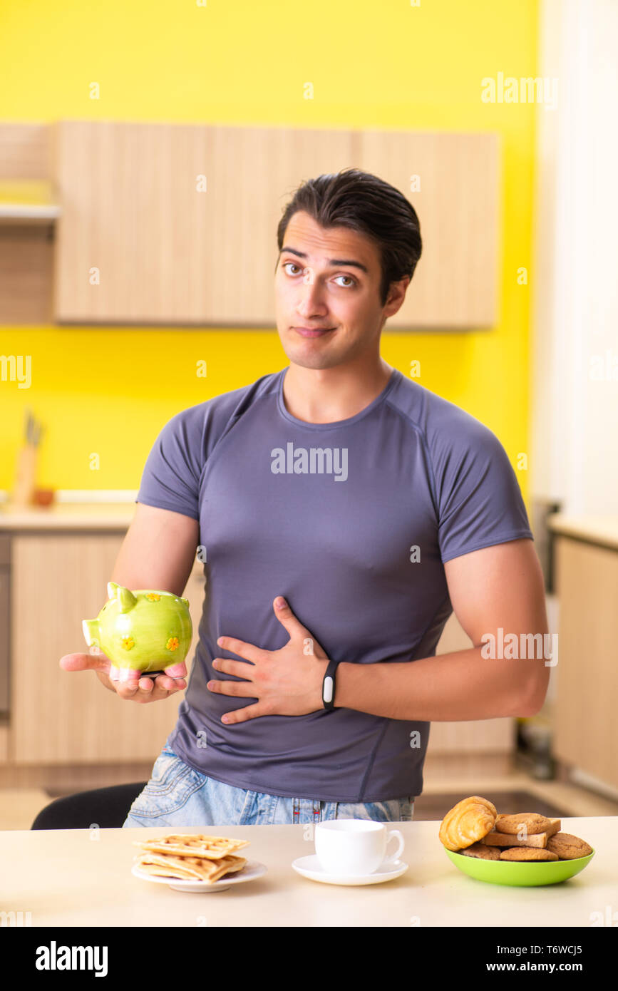 Young man in unhealthy food concept Stock Photo - Alamy