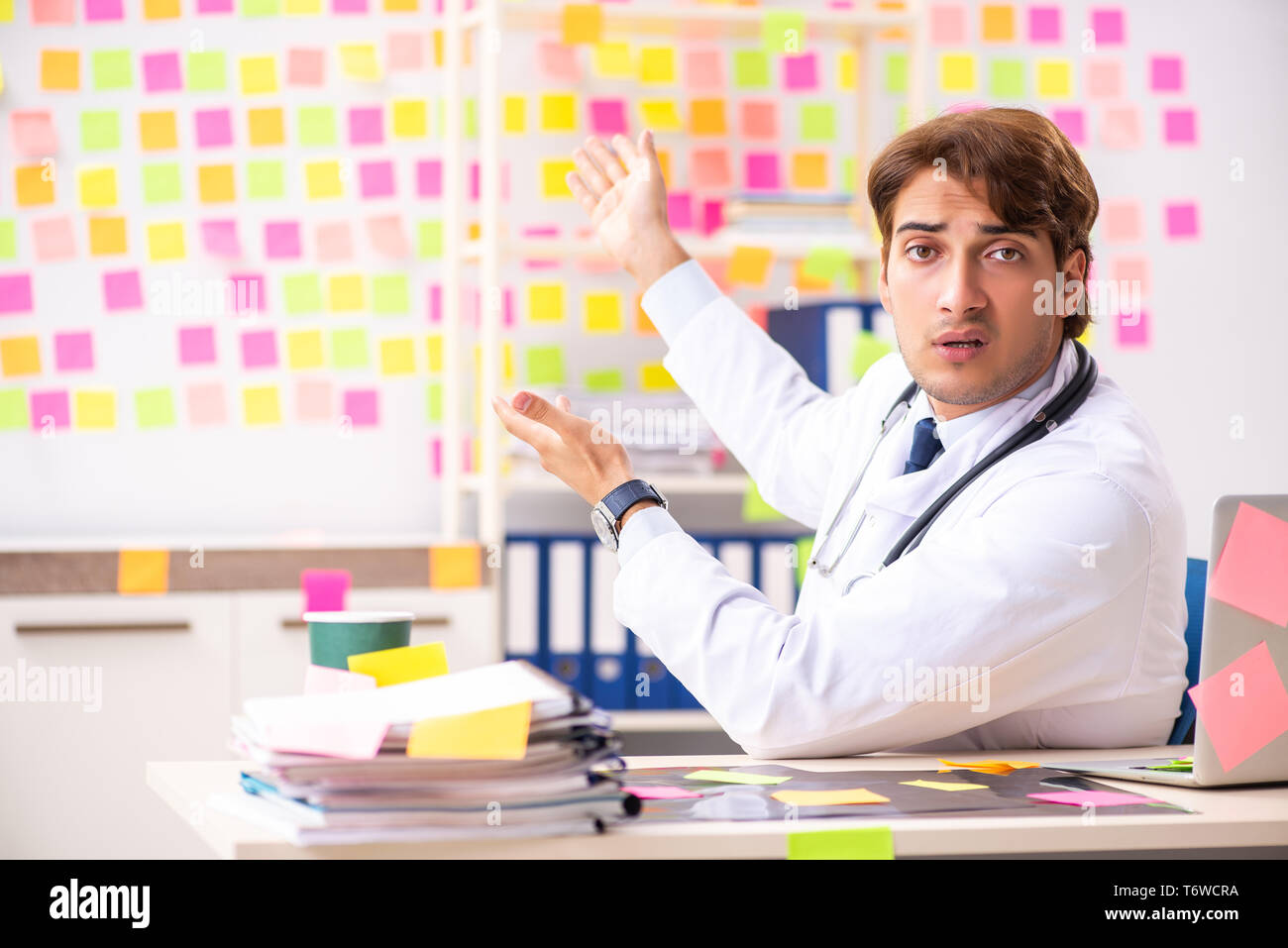 Male doctor with many conflicting prioritites Stock Photo - Alamy